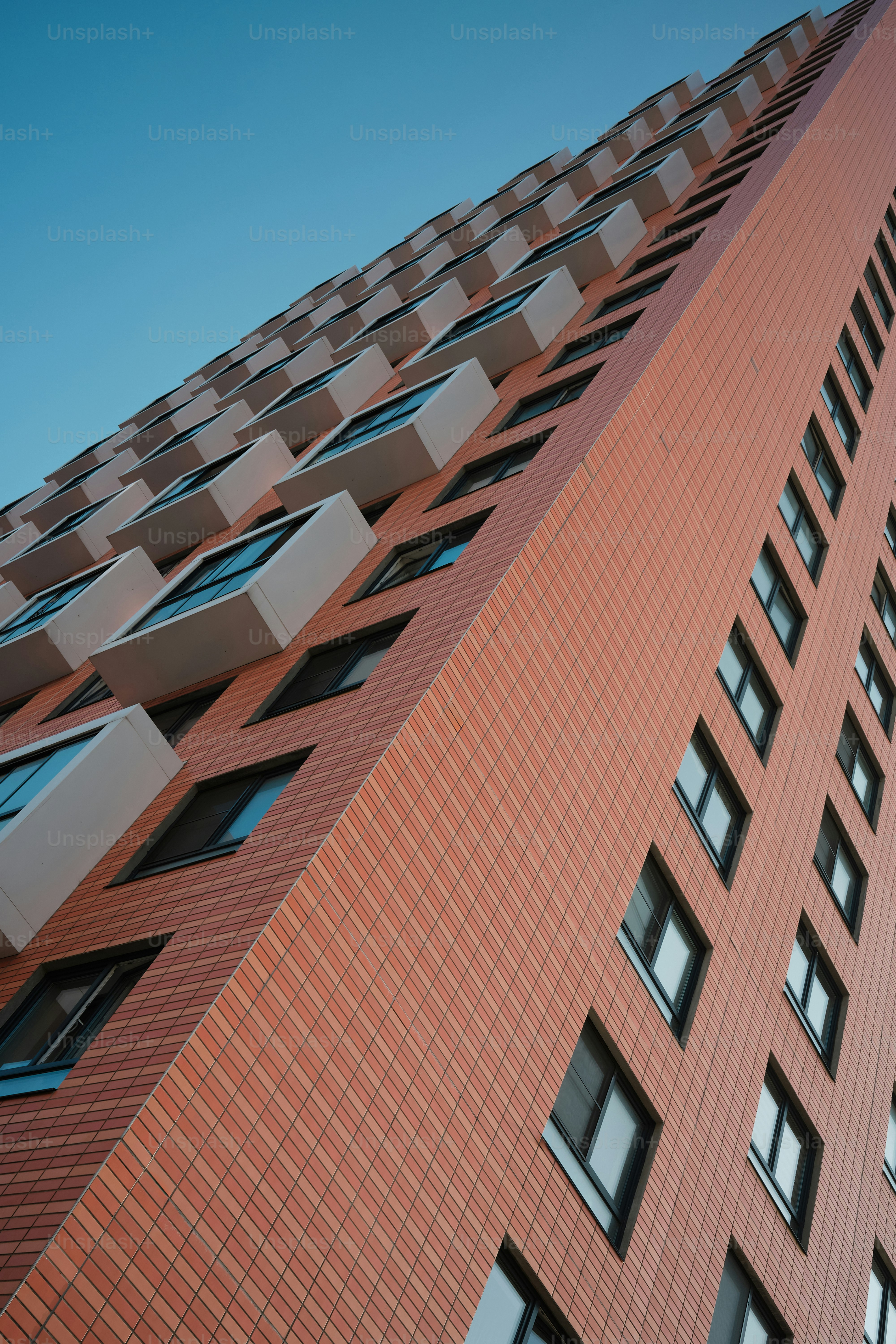 A tall red brick building with lots of windows photo – Colorful ...