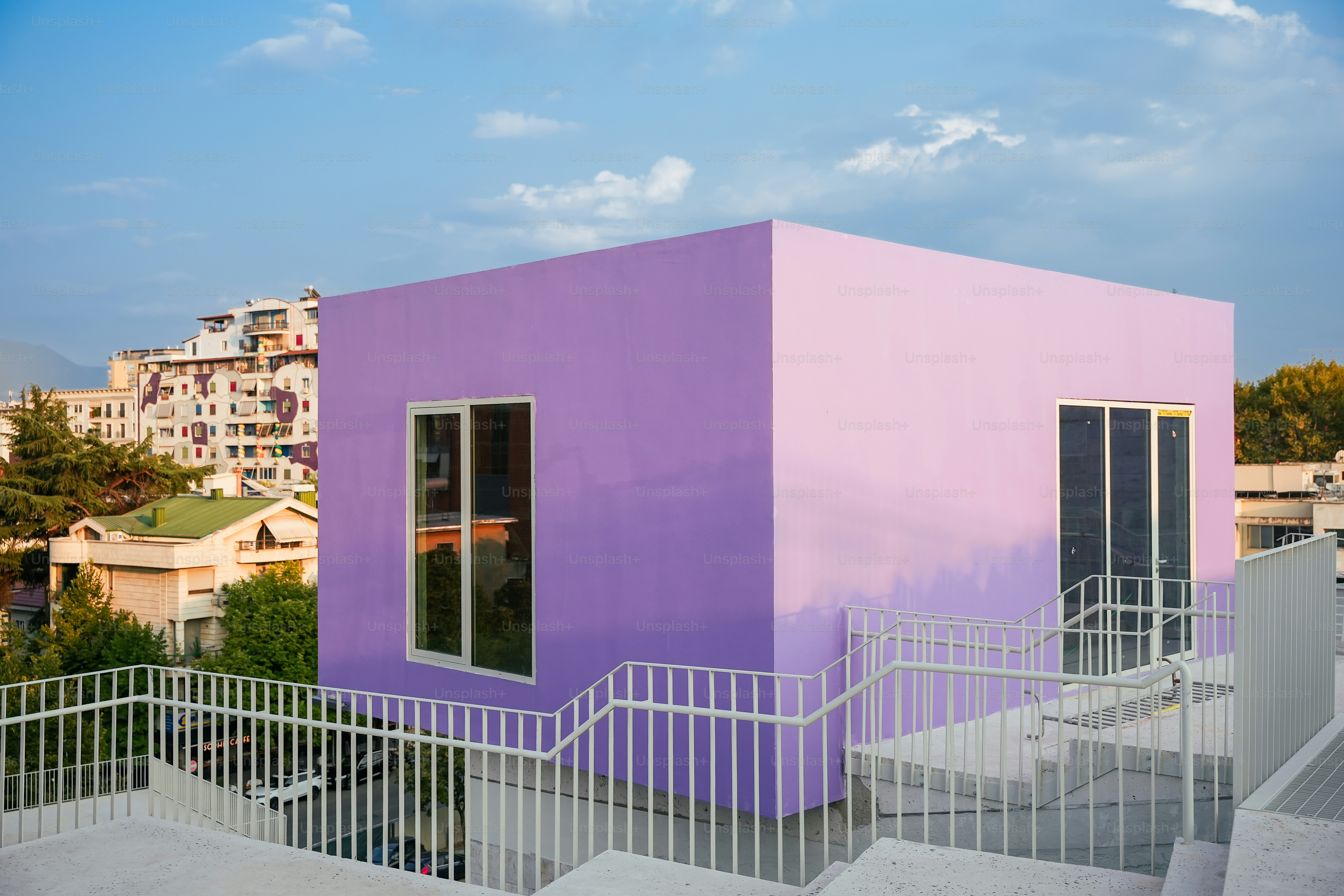 A pink and purple building with stairs leading up to it photo ...
