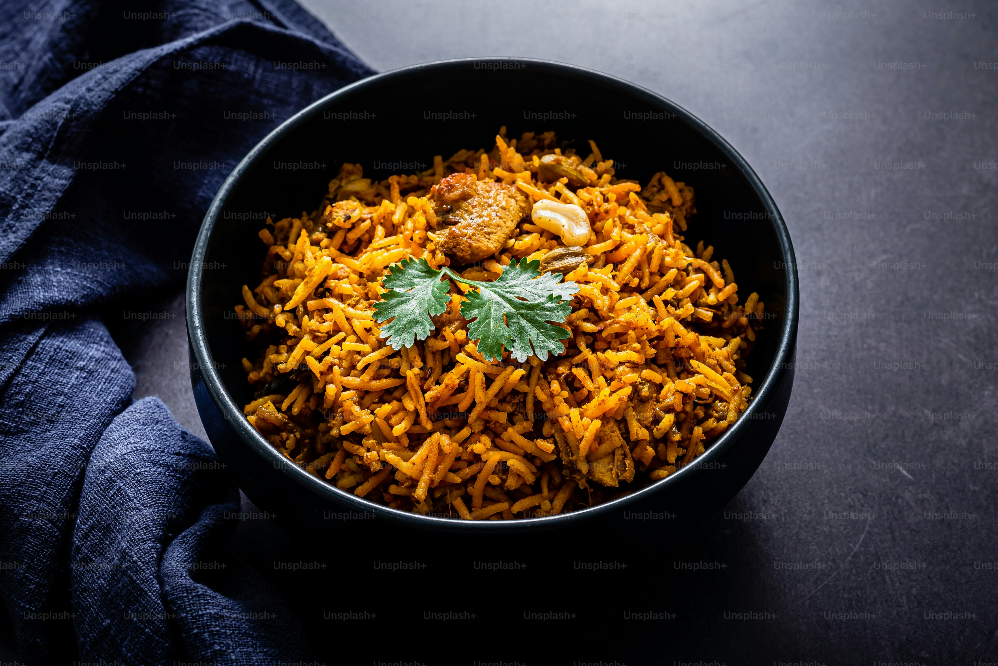 A bowl filled with rice and meat on top of a table photo – Indian food ...