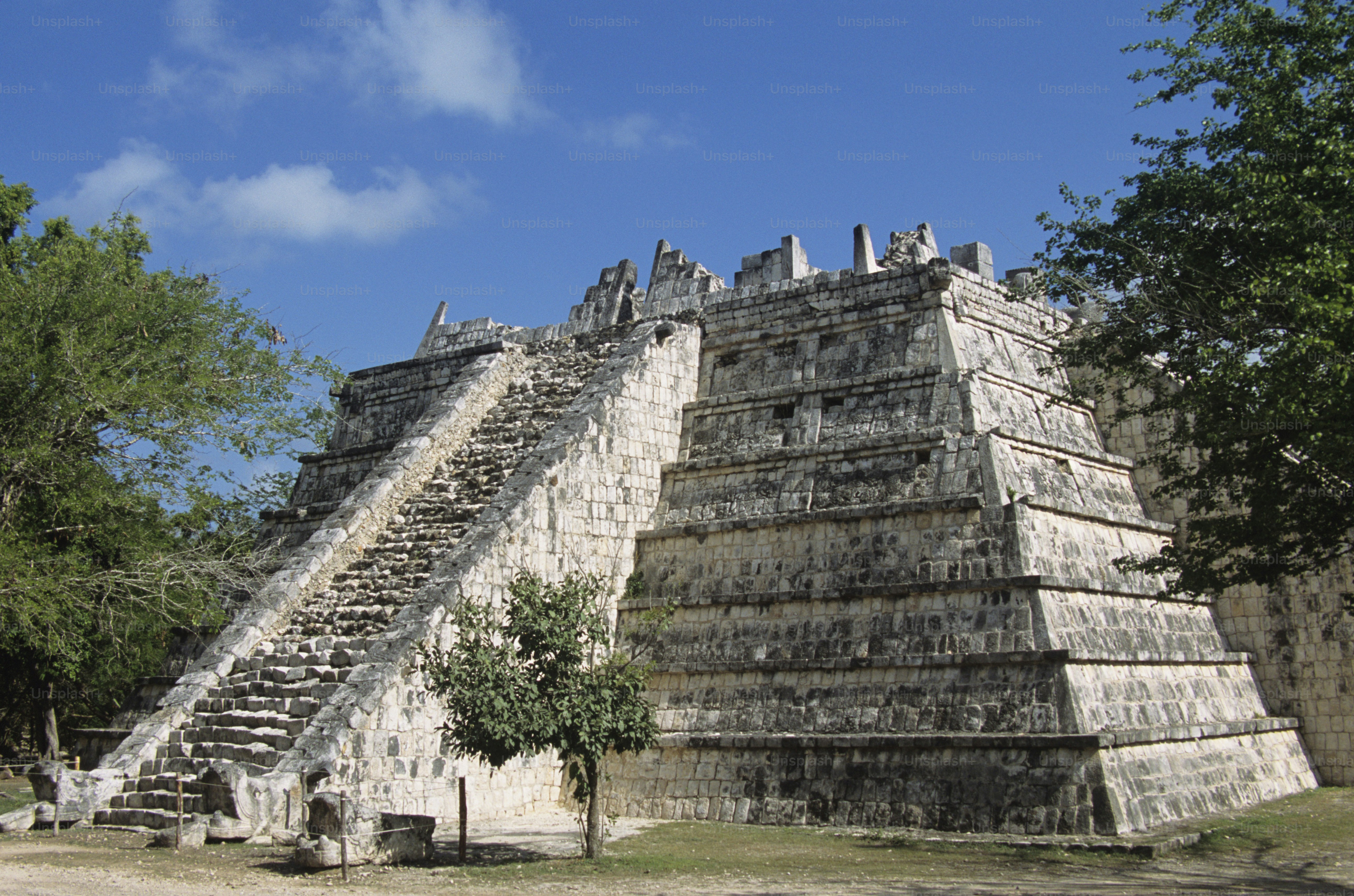 A large stone structure with a tree in front of it photo – History ...