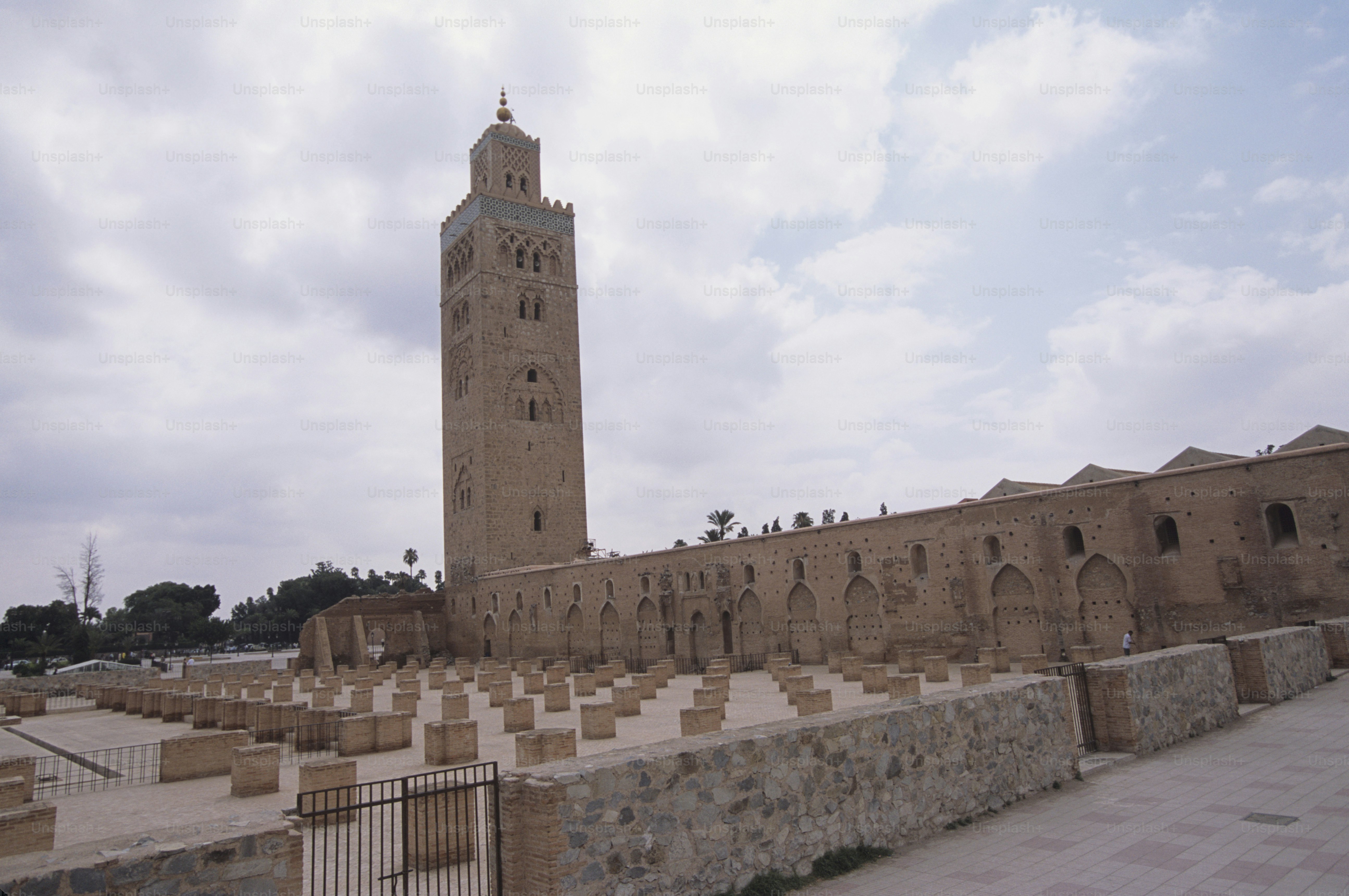 A very tall tower with a clock on it's side photo – Morocco Image on ...