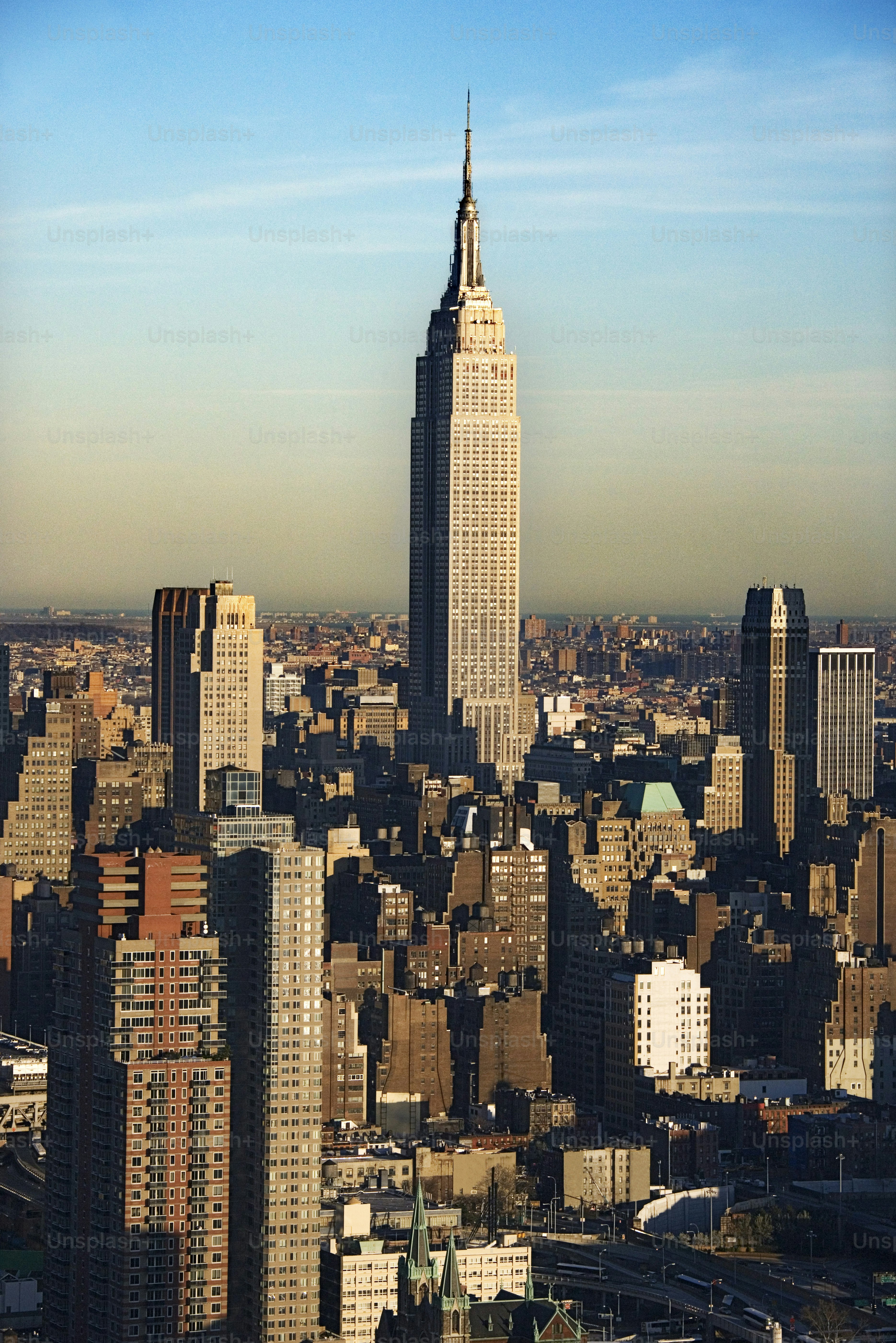 A view of a very tall building in a big city photo – Empire state ...
