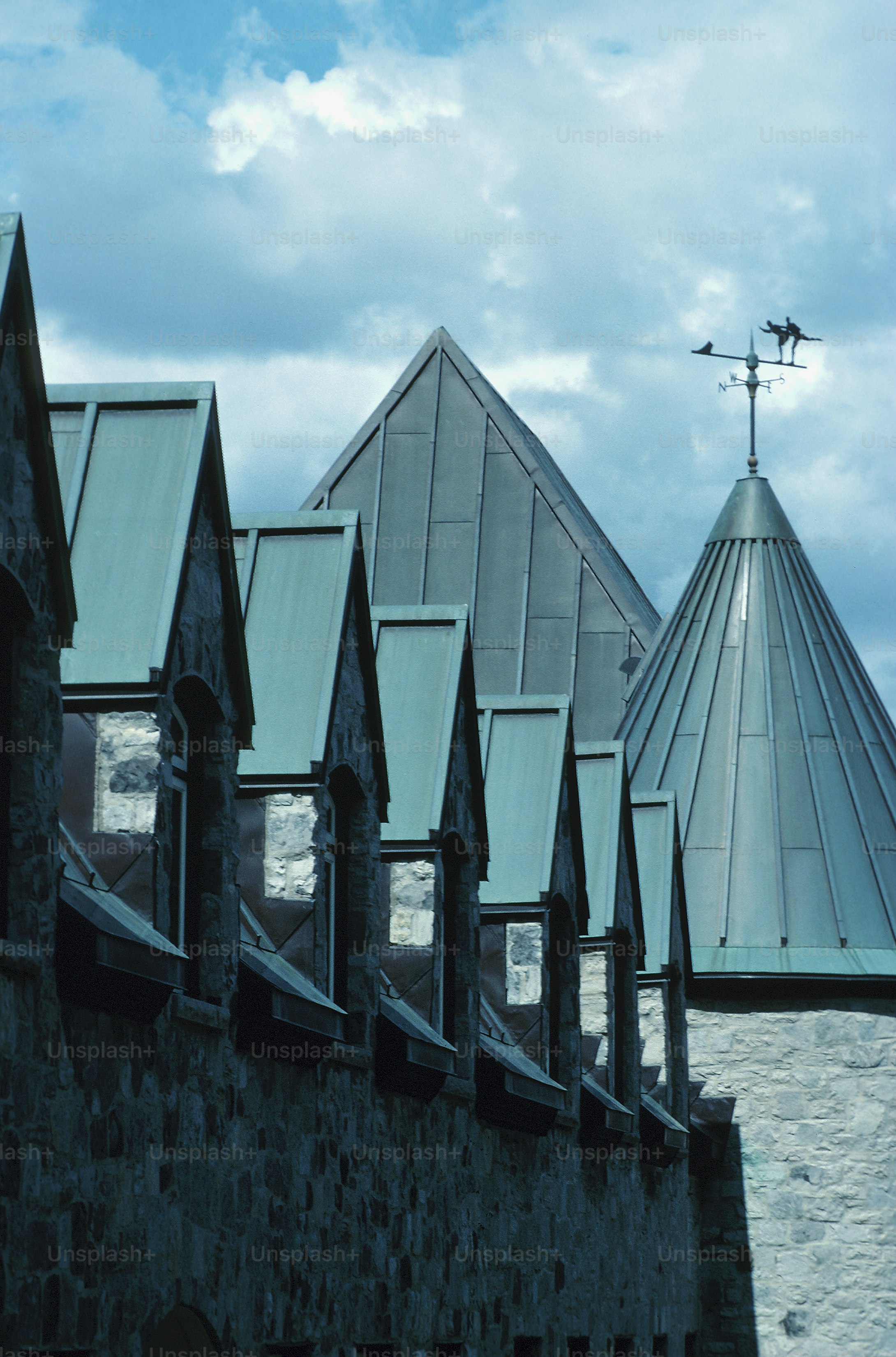 A view of a building with a weather vane on top of it photo – Stone ...