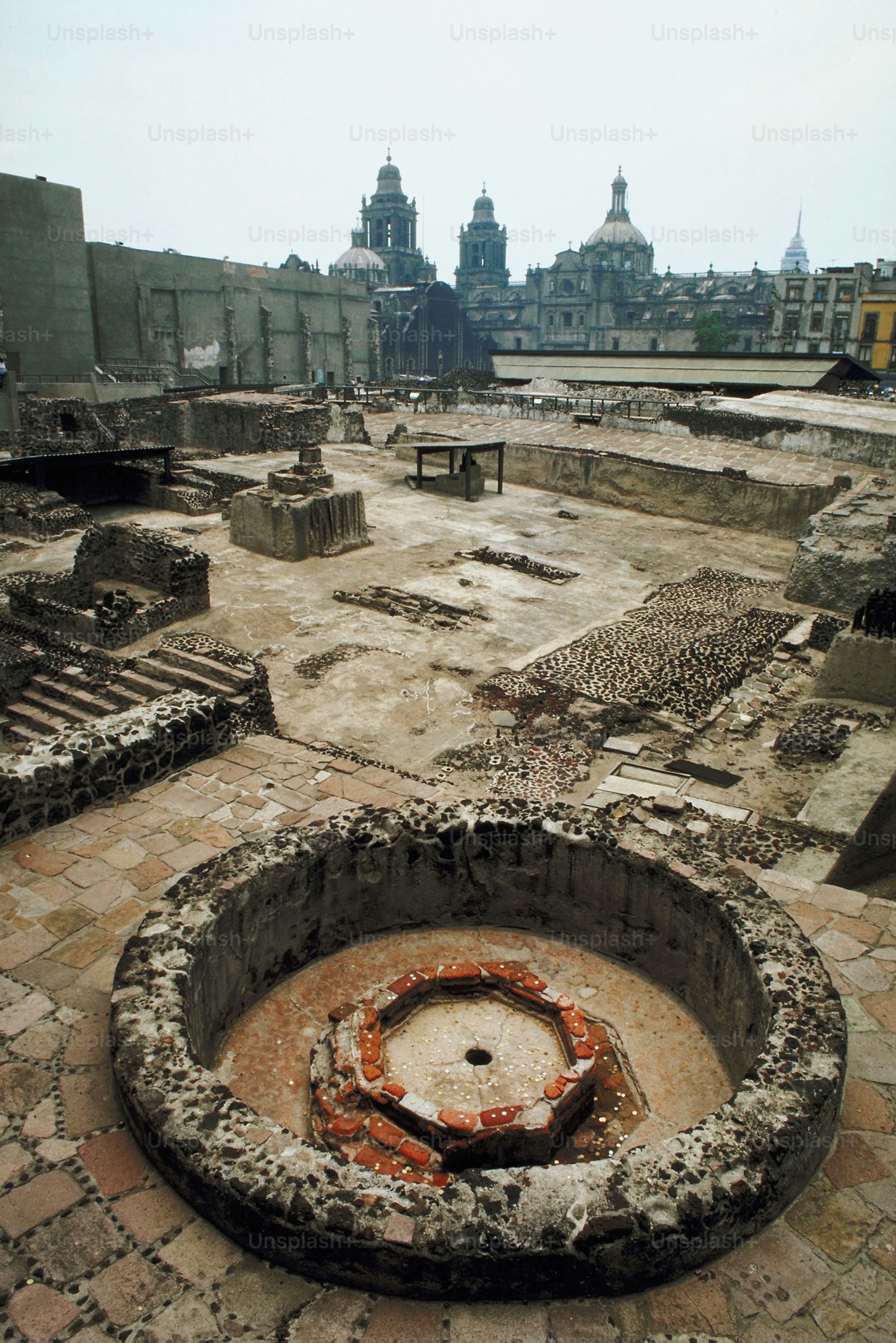 A circular stone fire pit in the middle of a courtyard photo – Old ruin ...