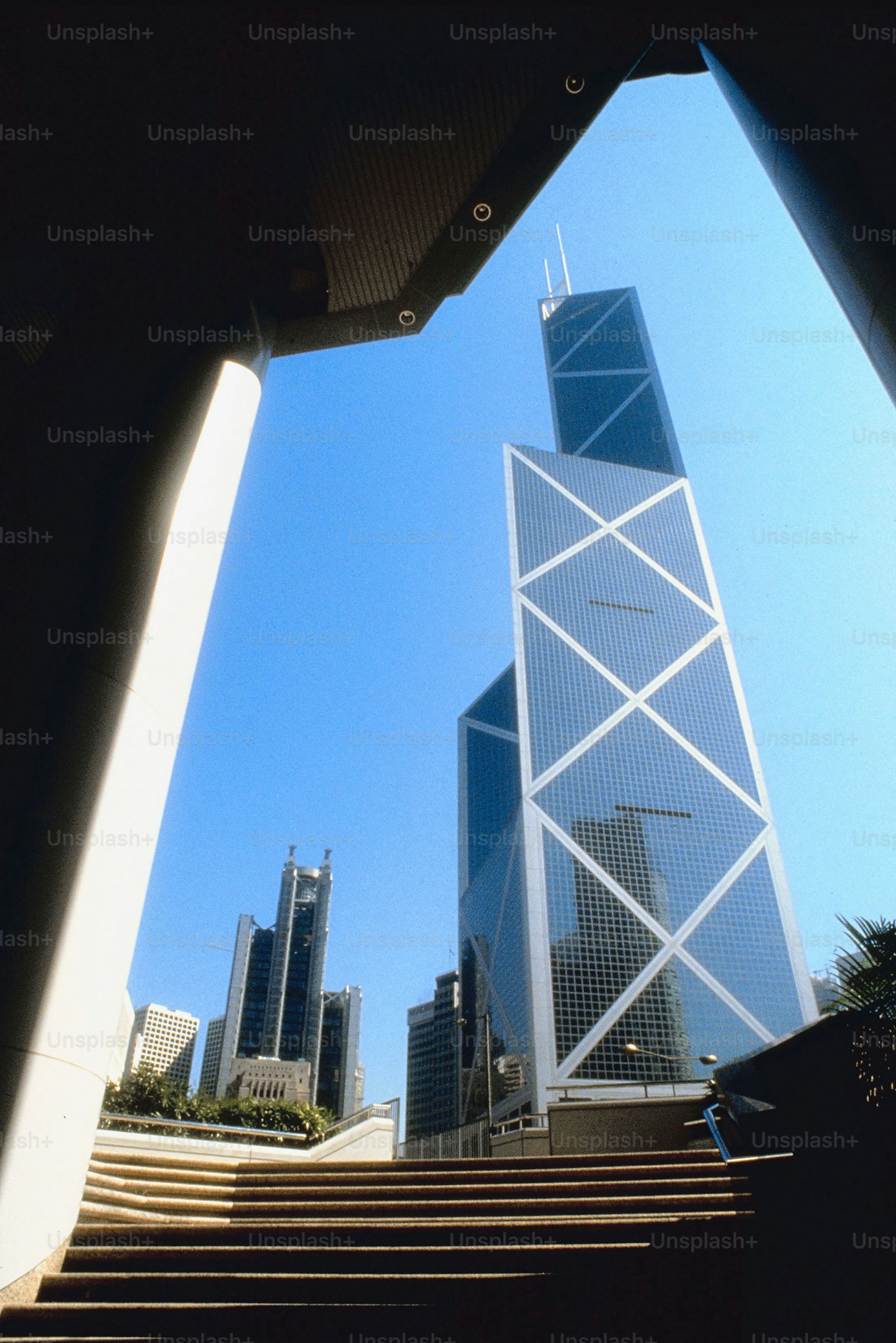 A very tall building towering over a city photo – Color image Image on ...