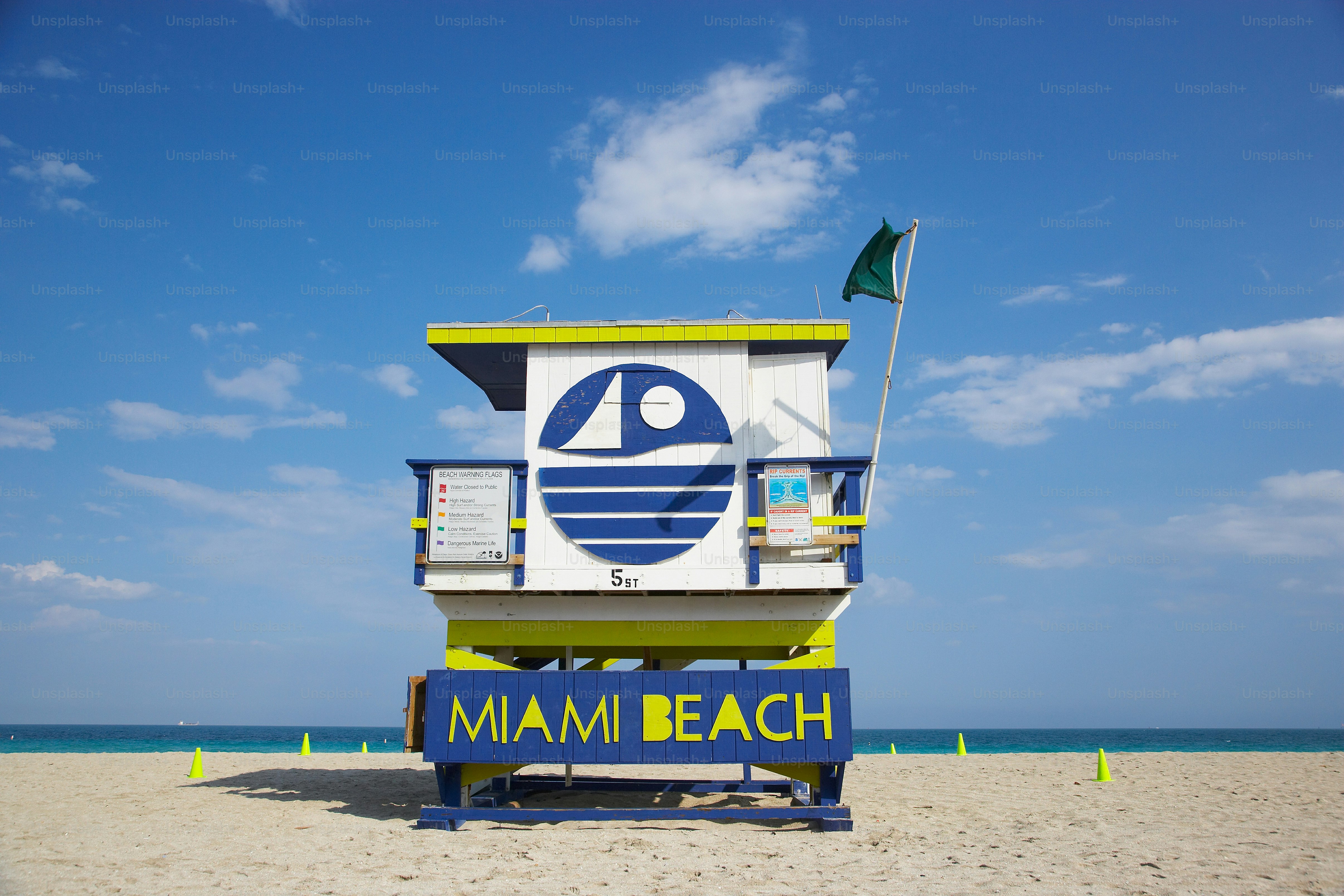 A lifeguard stand on the beach with a flag on it photo – Blue Image on ...