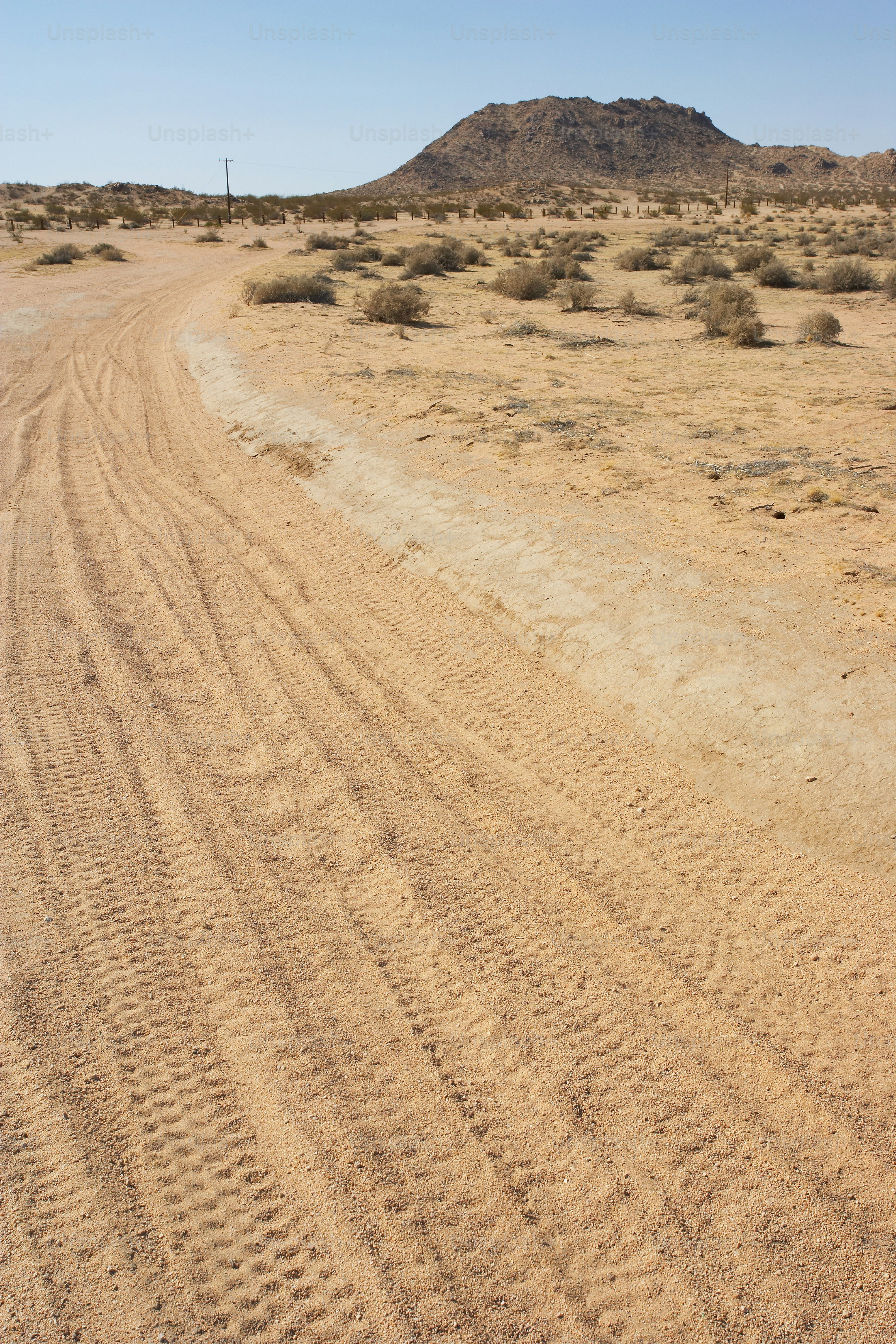 Un chemin de terre au milieu d’un désert photo – Ensoleillé Photo sur ...