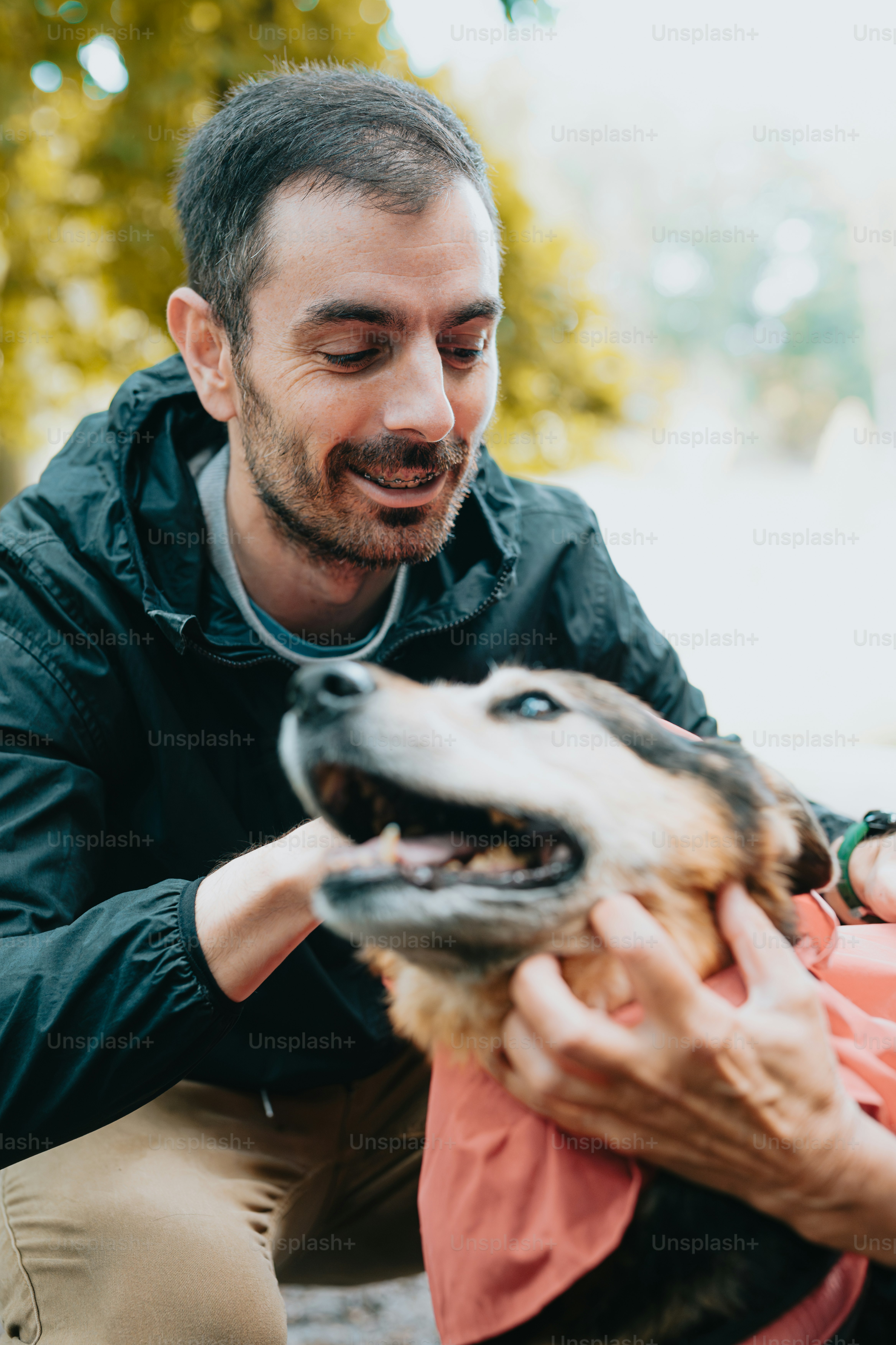 A man petting a dog with his mouth open photo – Lifestyle Image on Unsplash