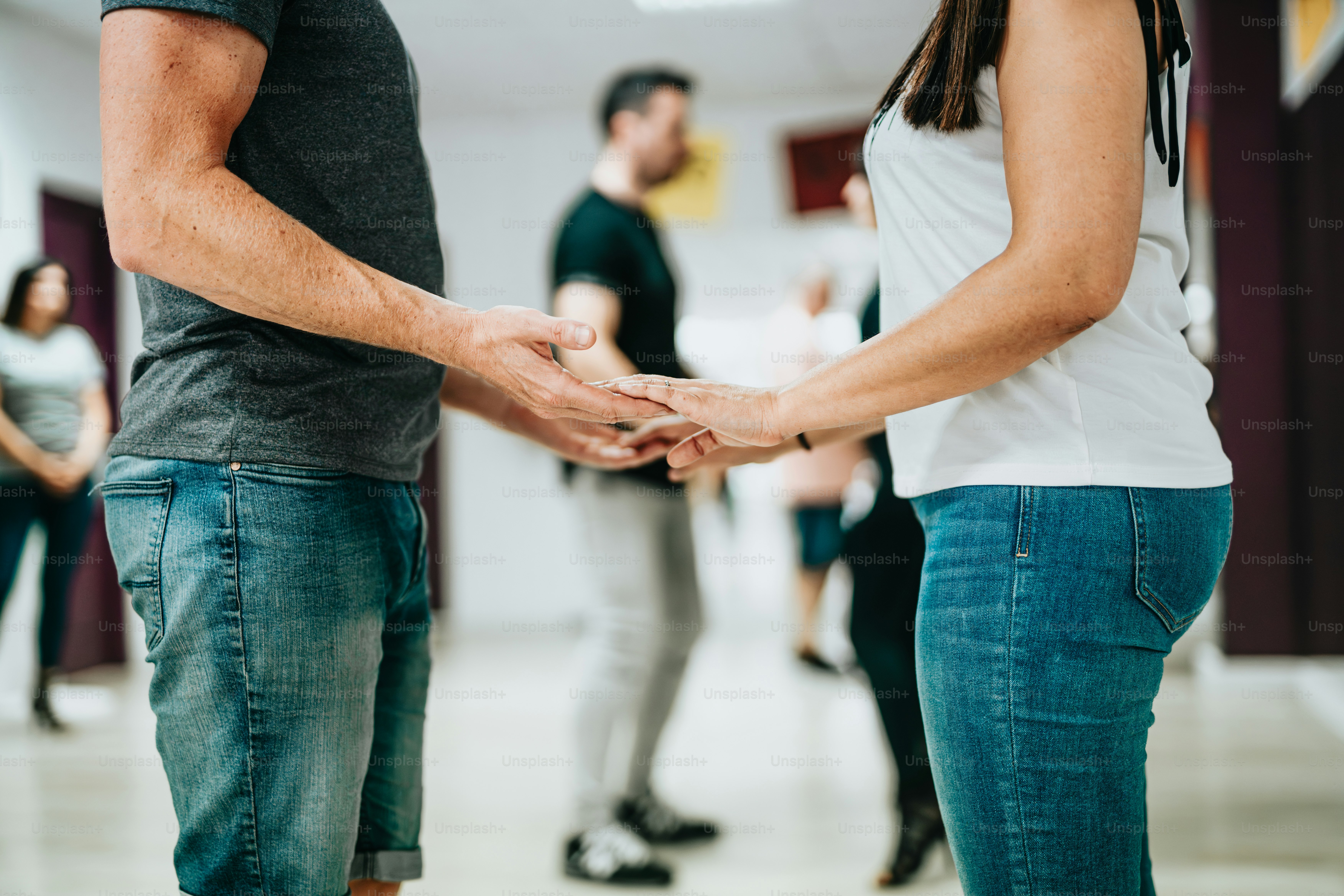 A group of people standing around each other in a room photo – Salsa ...