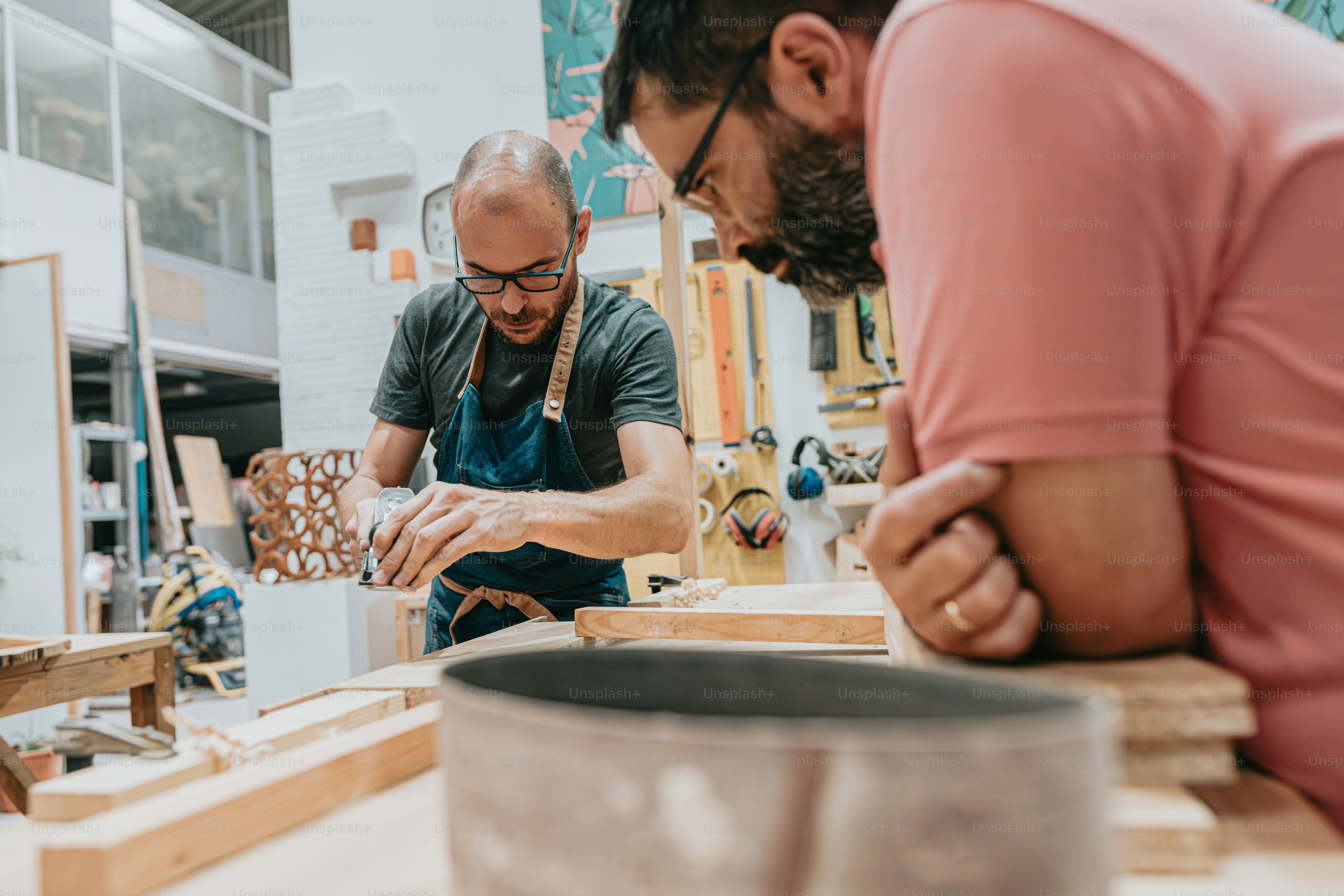 A couple of men working on a piece of wood photo – Woodwork Image on ...