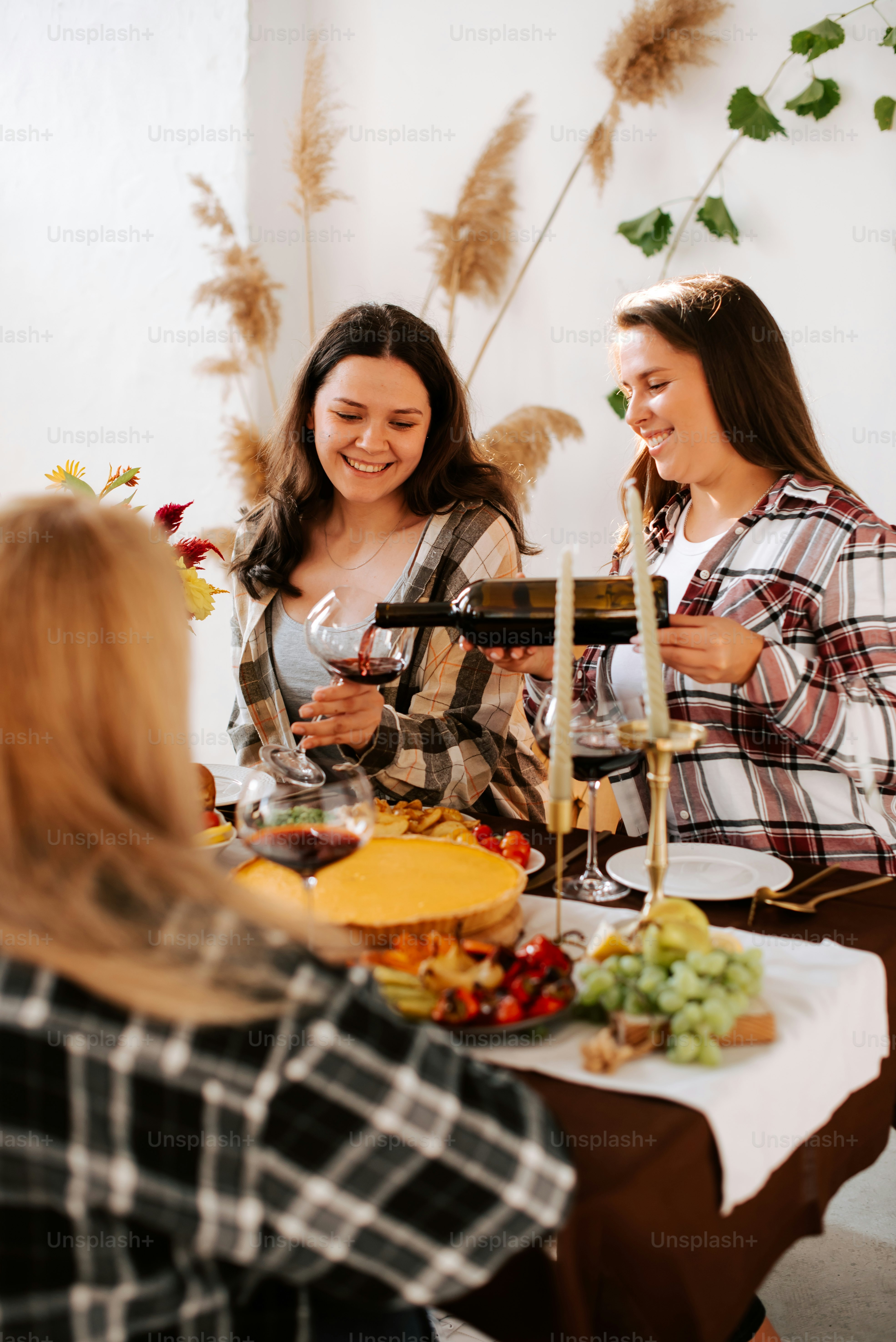 A group of women sitting around a table with food photo – Thanksgiving ...