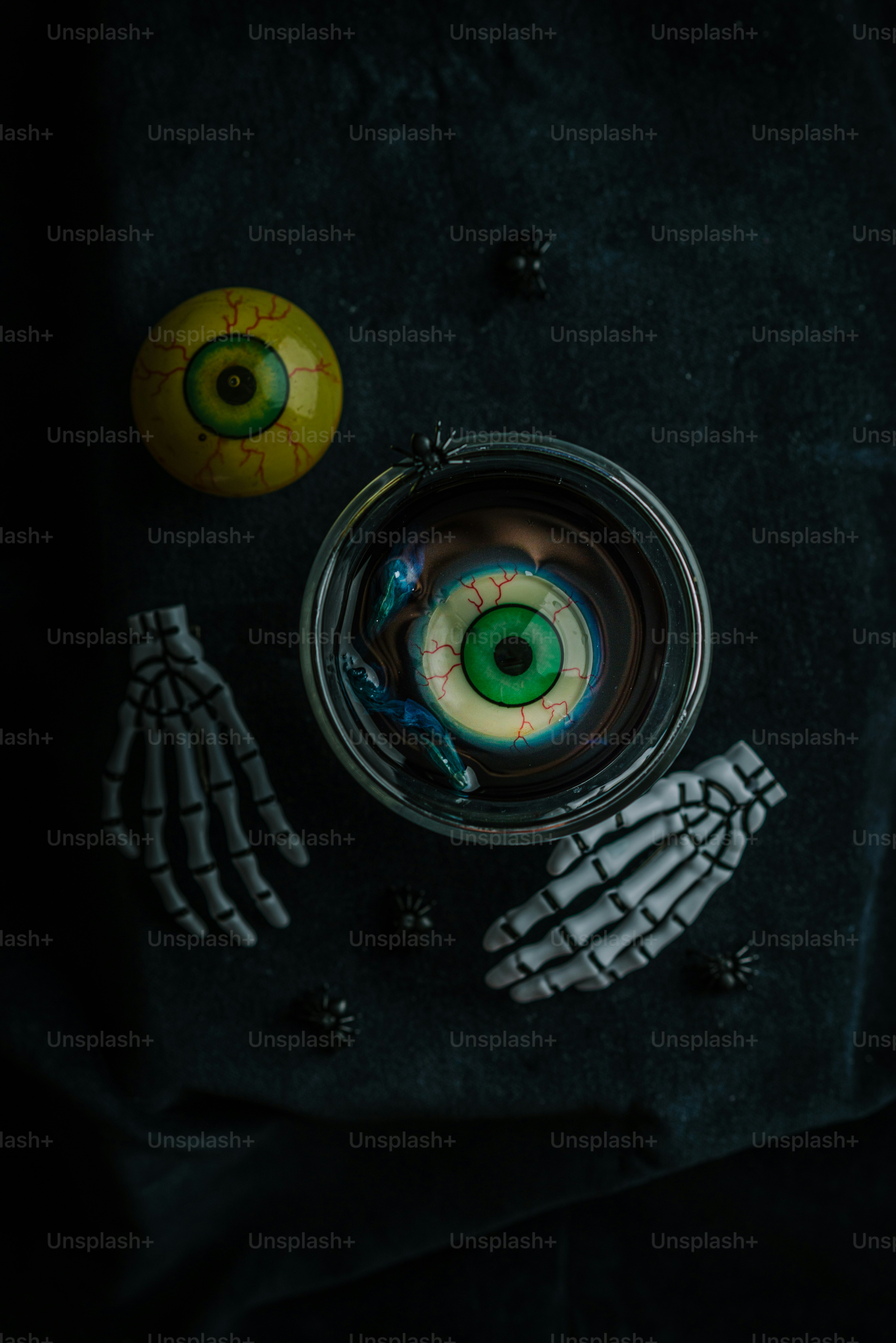 A skeleton hand holding a toothbrush next to a glass of blue liquid ...