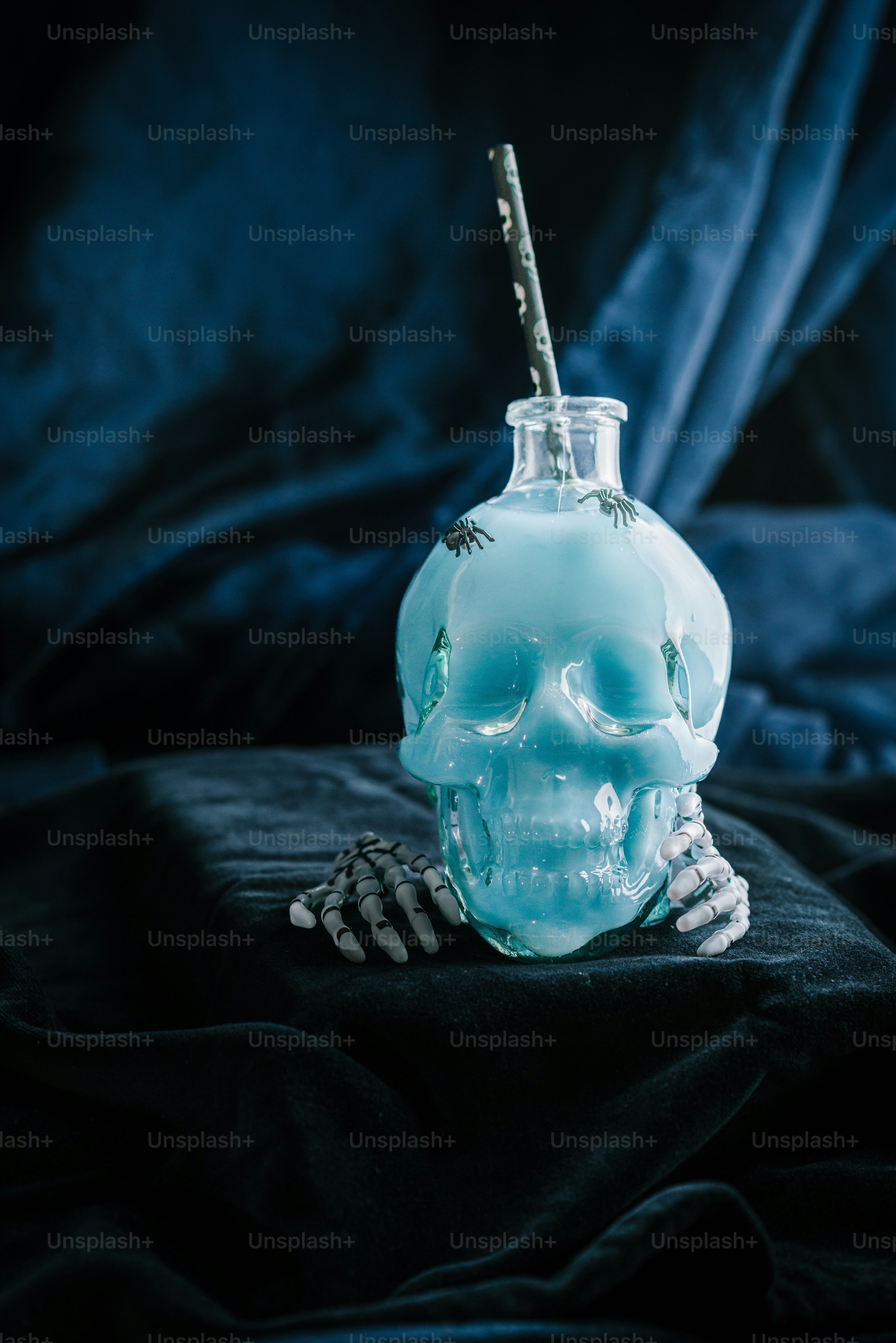 A skeleton hand holding a toothbrush next to a glass of blue liquid ...