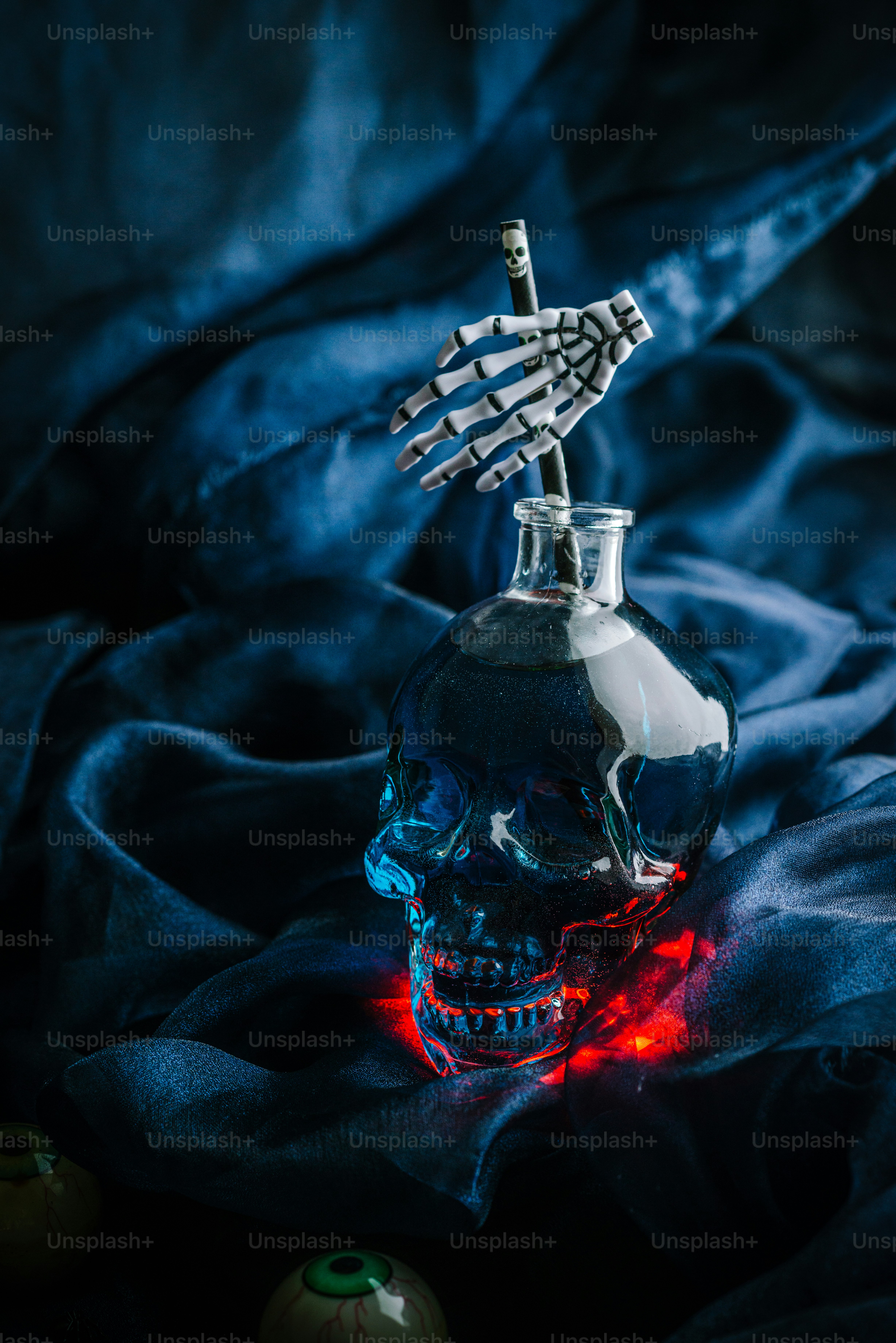 A skeleton hand holding a toothbrush next to a glass of blue liquid ...