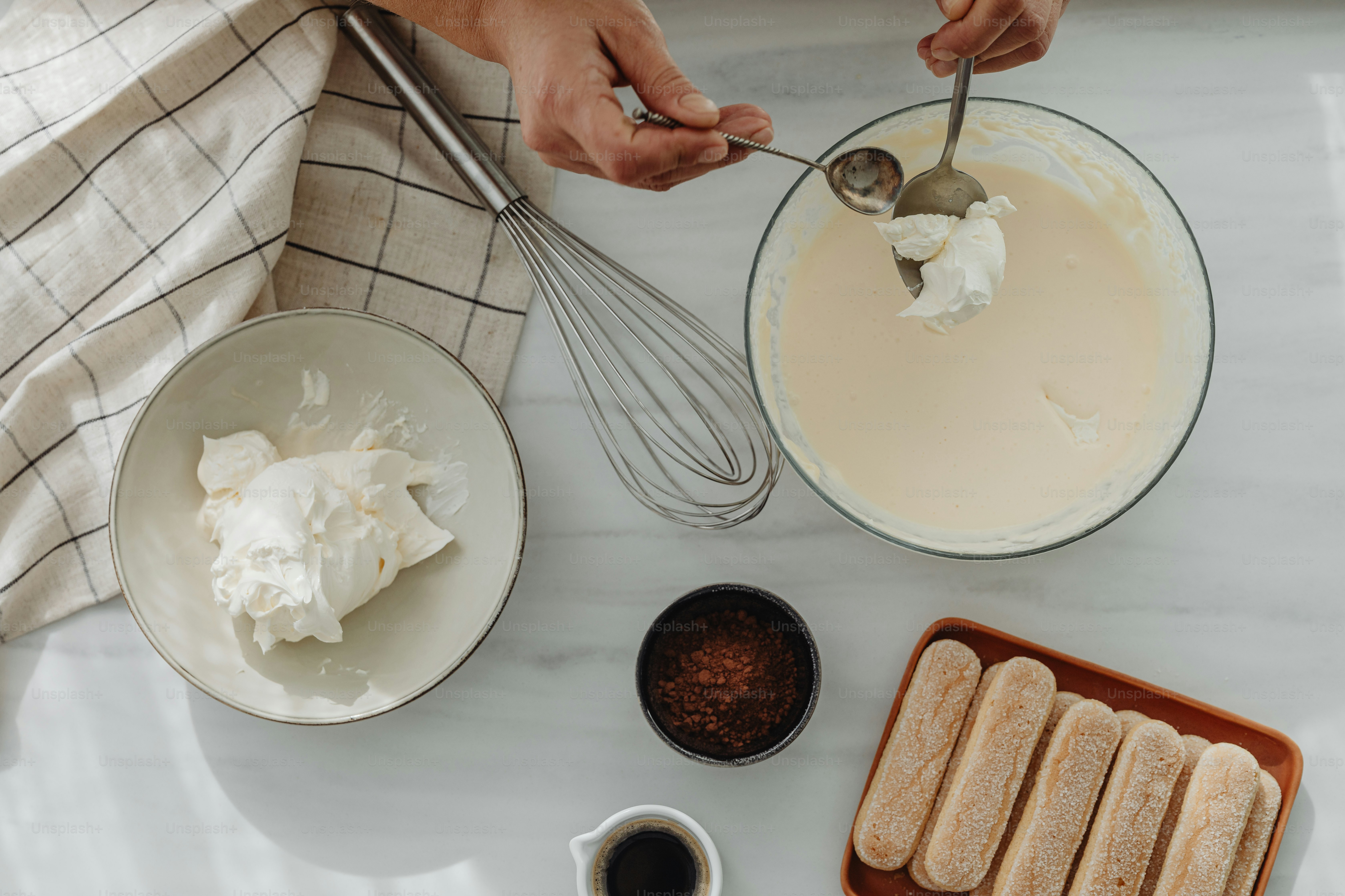 A person mixing ingredients in a bowl on a table photo – Dessert Image ...