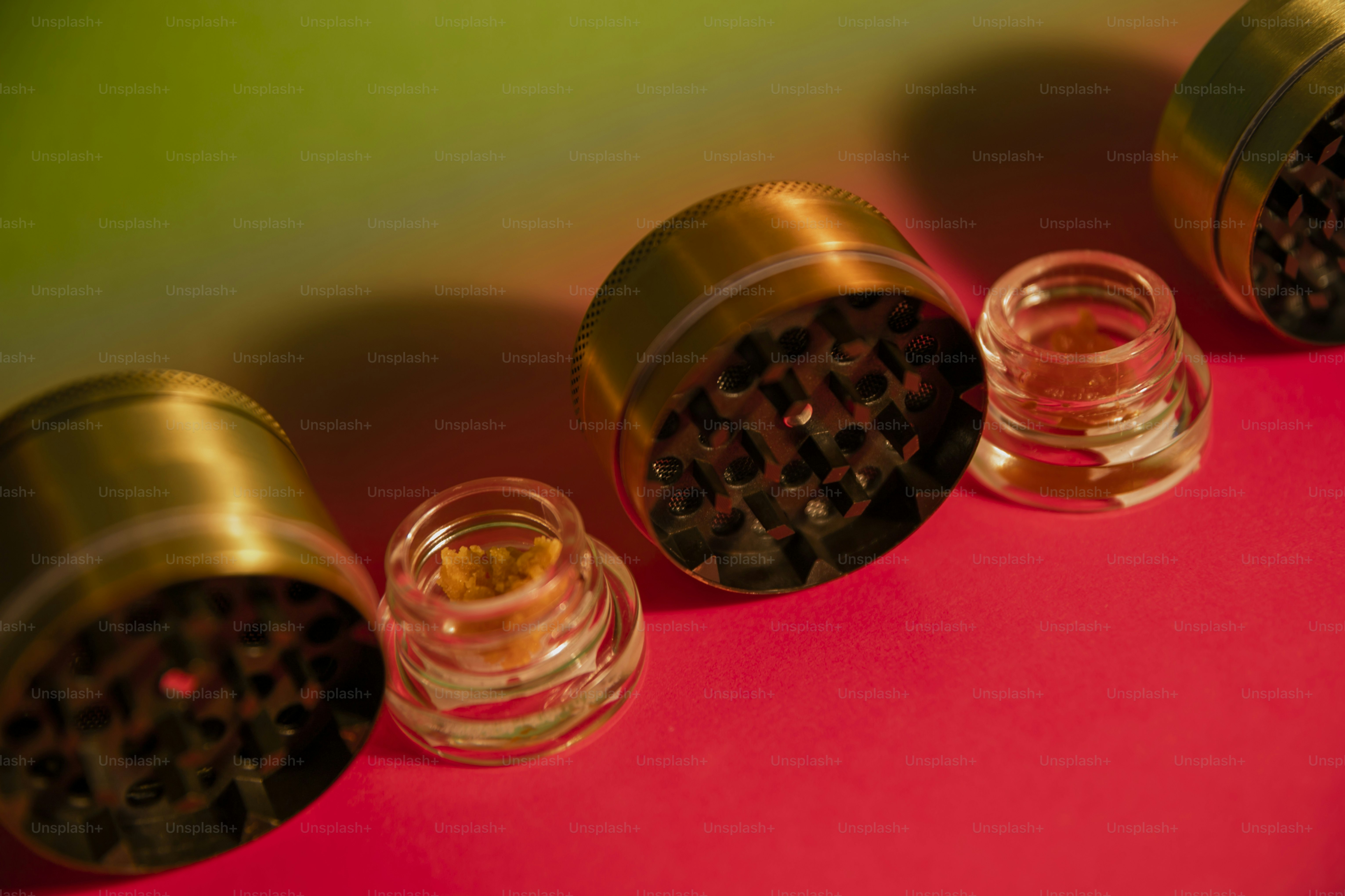 Three small grinders sitting next to each other on a red surface photo ...