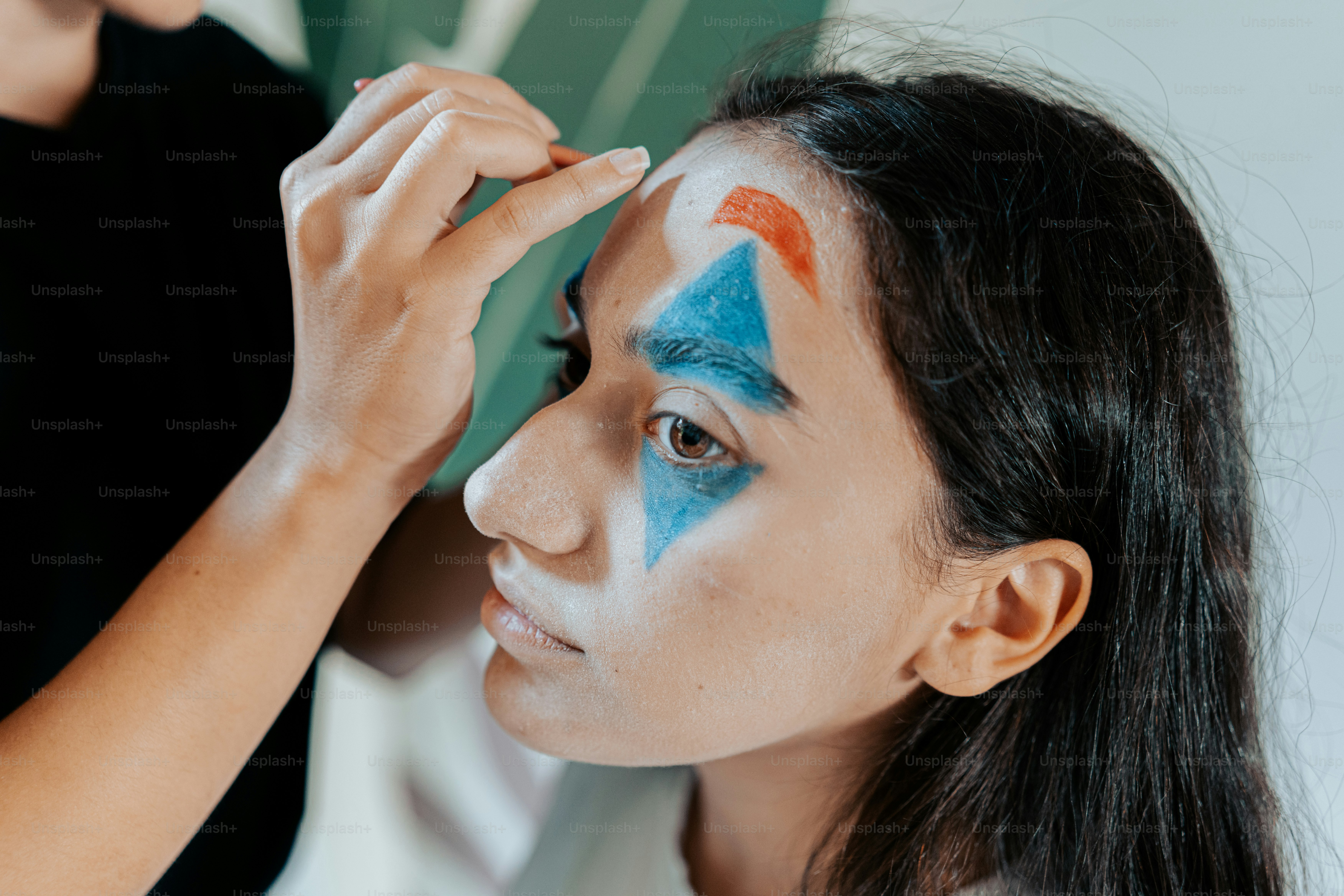A woman with blue and orange face paint on her face photo – Halloween ...