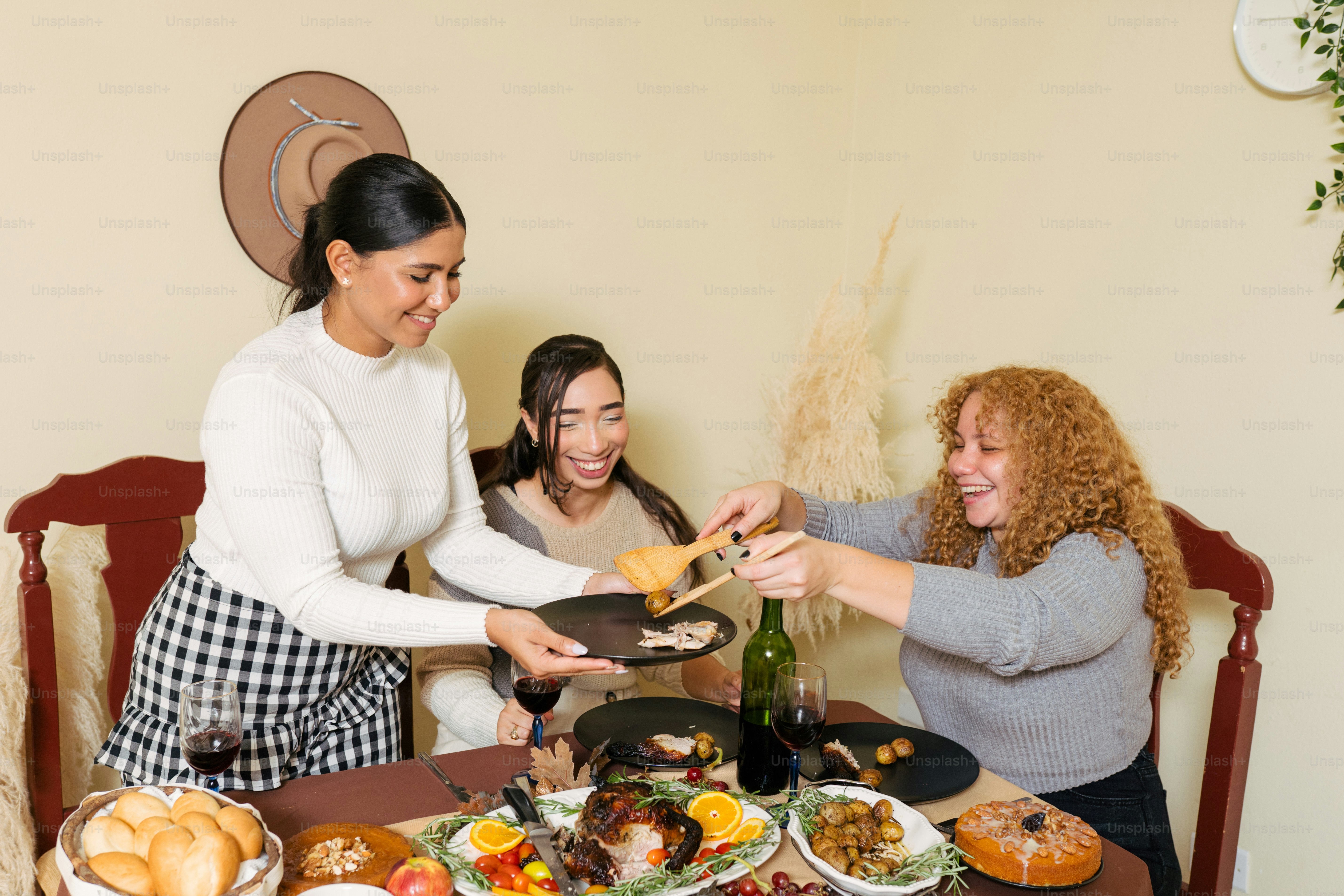A group of women standing around a table filled with food photo ...