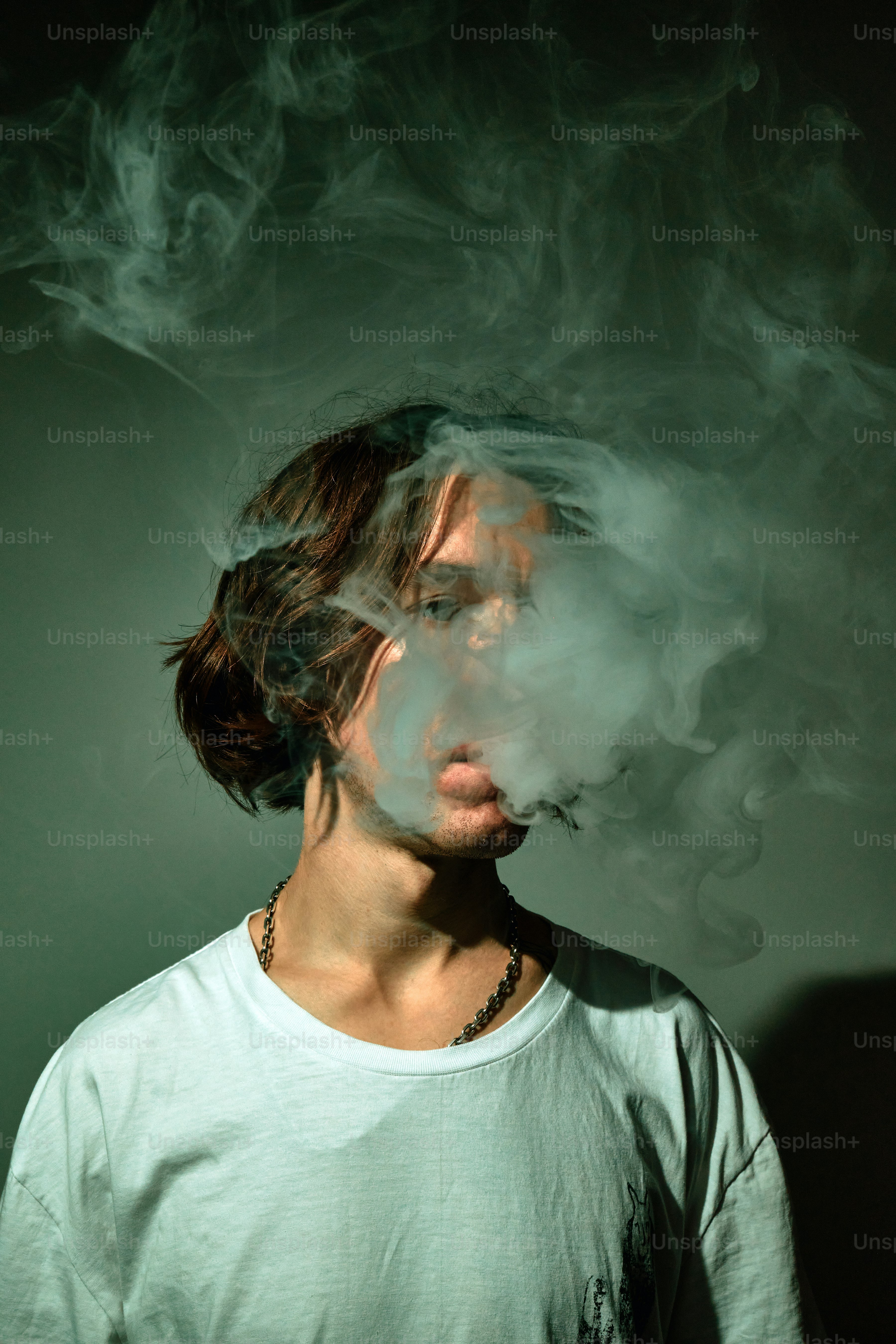 A man smoking a cigarette with red smoke coming out of his mouth photo ...