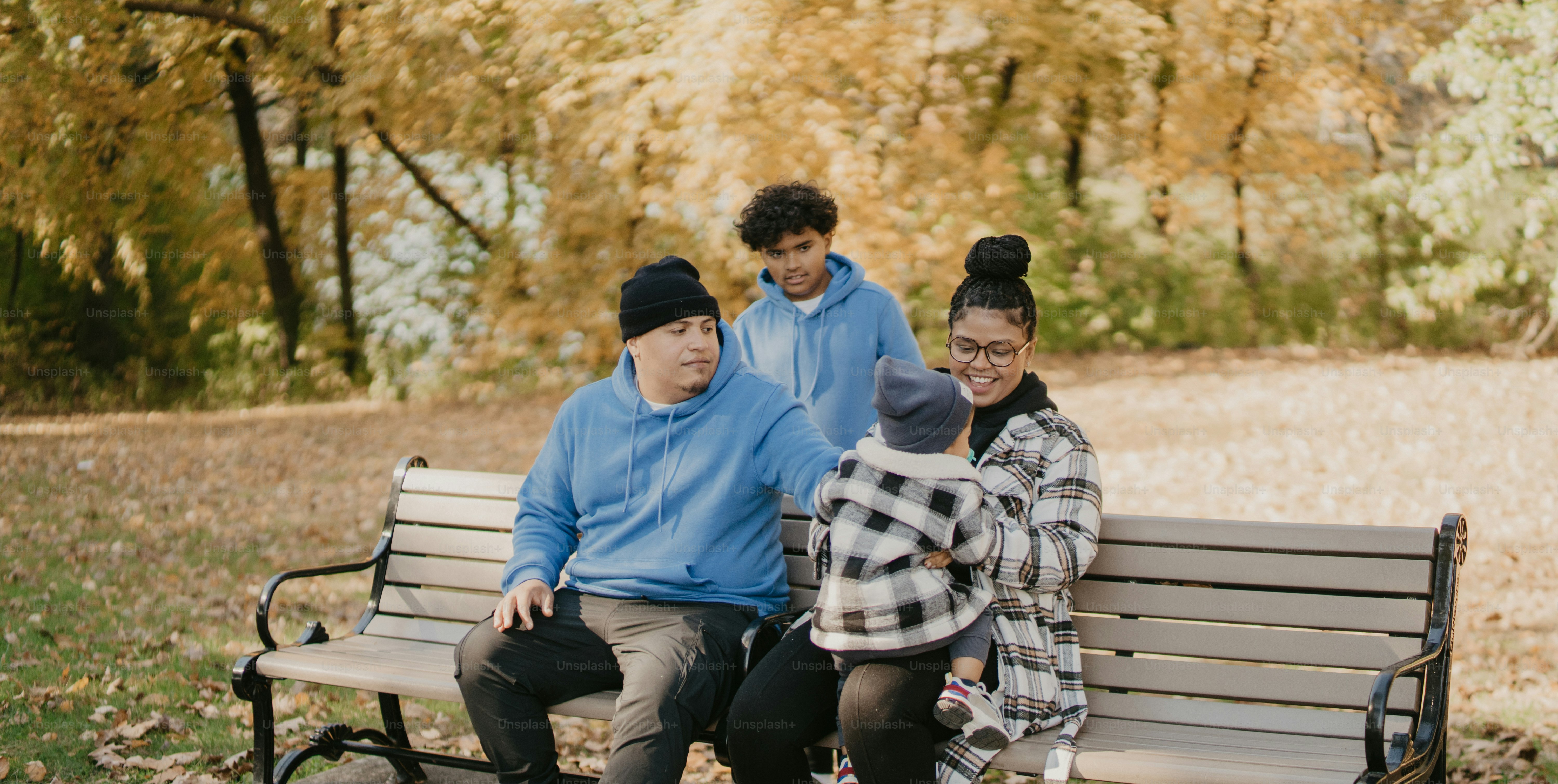 A group of people sitting on a park bench photo – Family Image on Unsplash