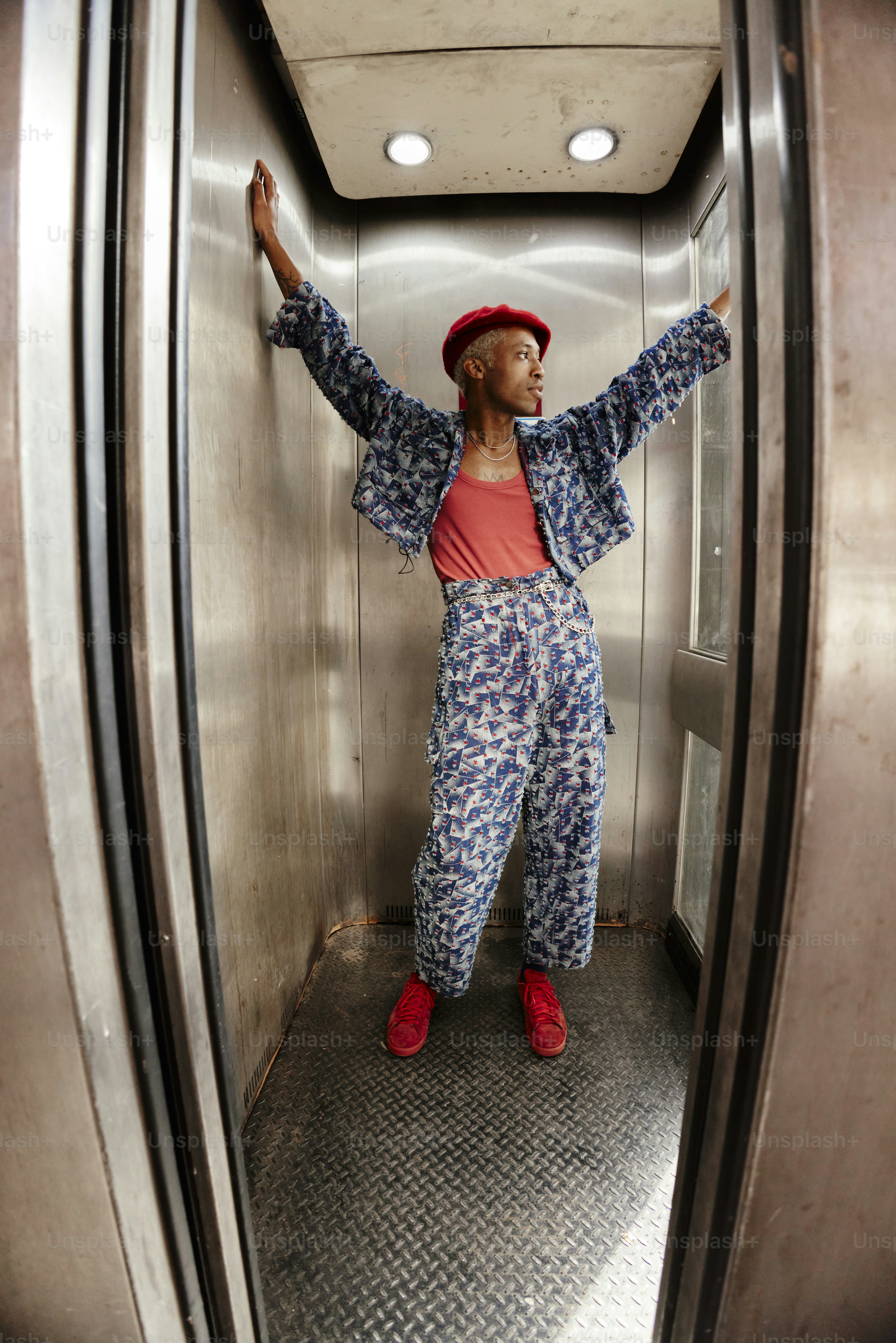 A woman in a red hat is standing in an elevator photo – Fashion ...