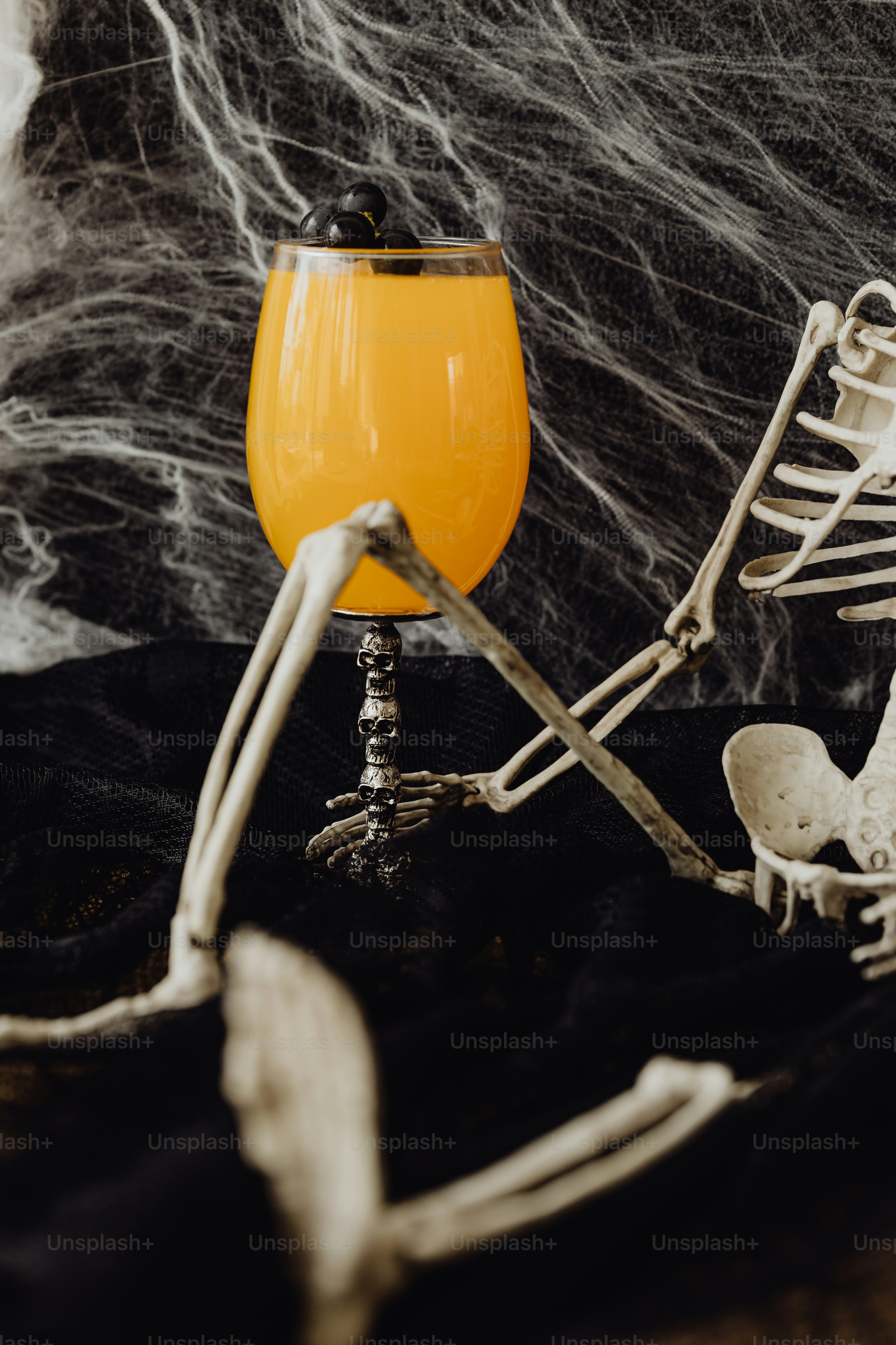 A skeleton holding a glass of orange juice photo – Drinks Image on Unsplash
