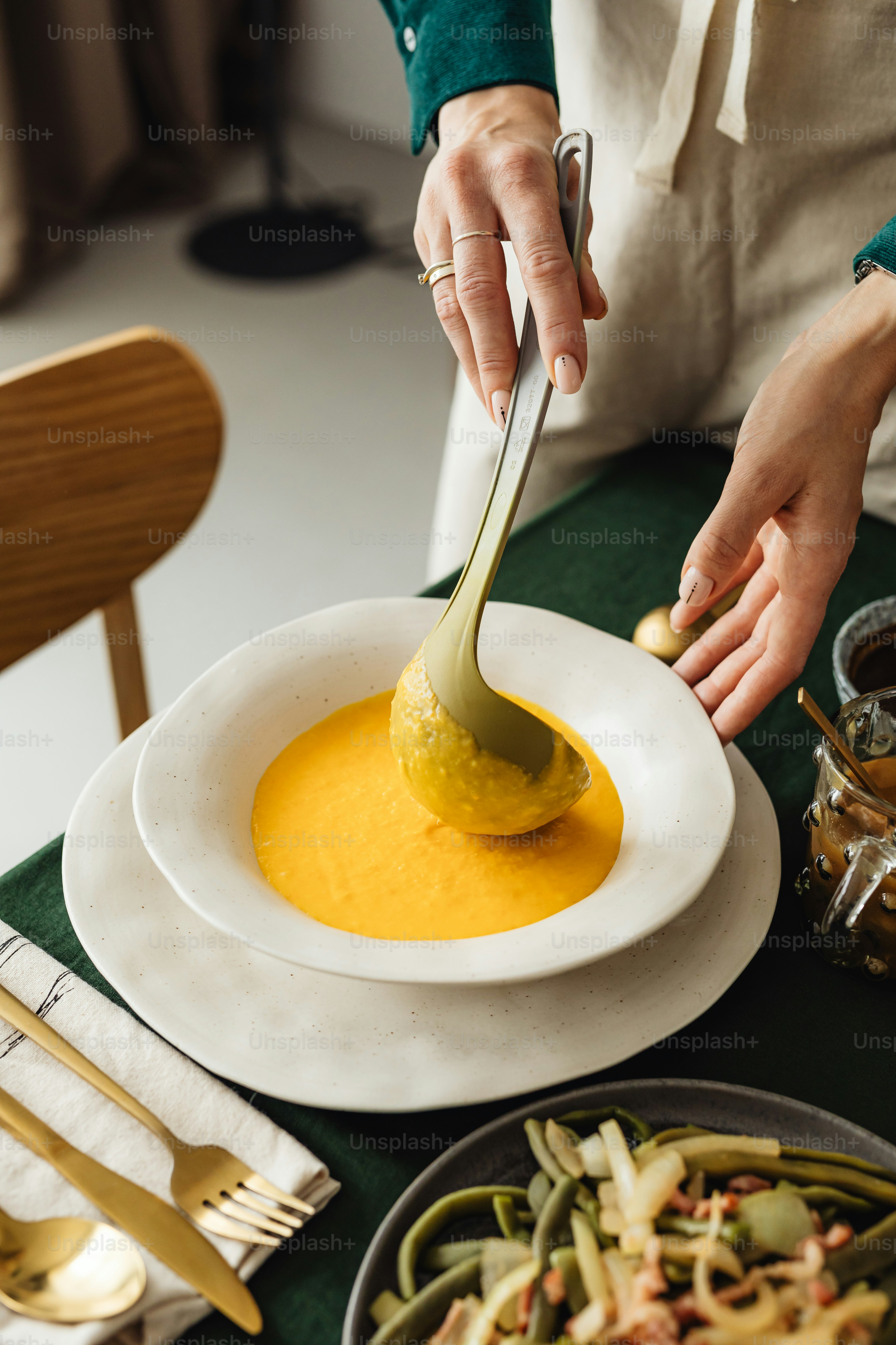 A person is spooning a spoon into a bowl of soup photo – Thanksgiving ...