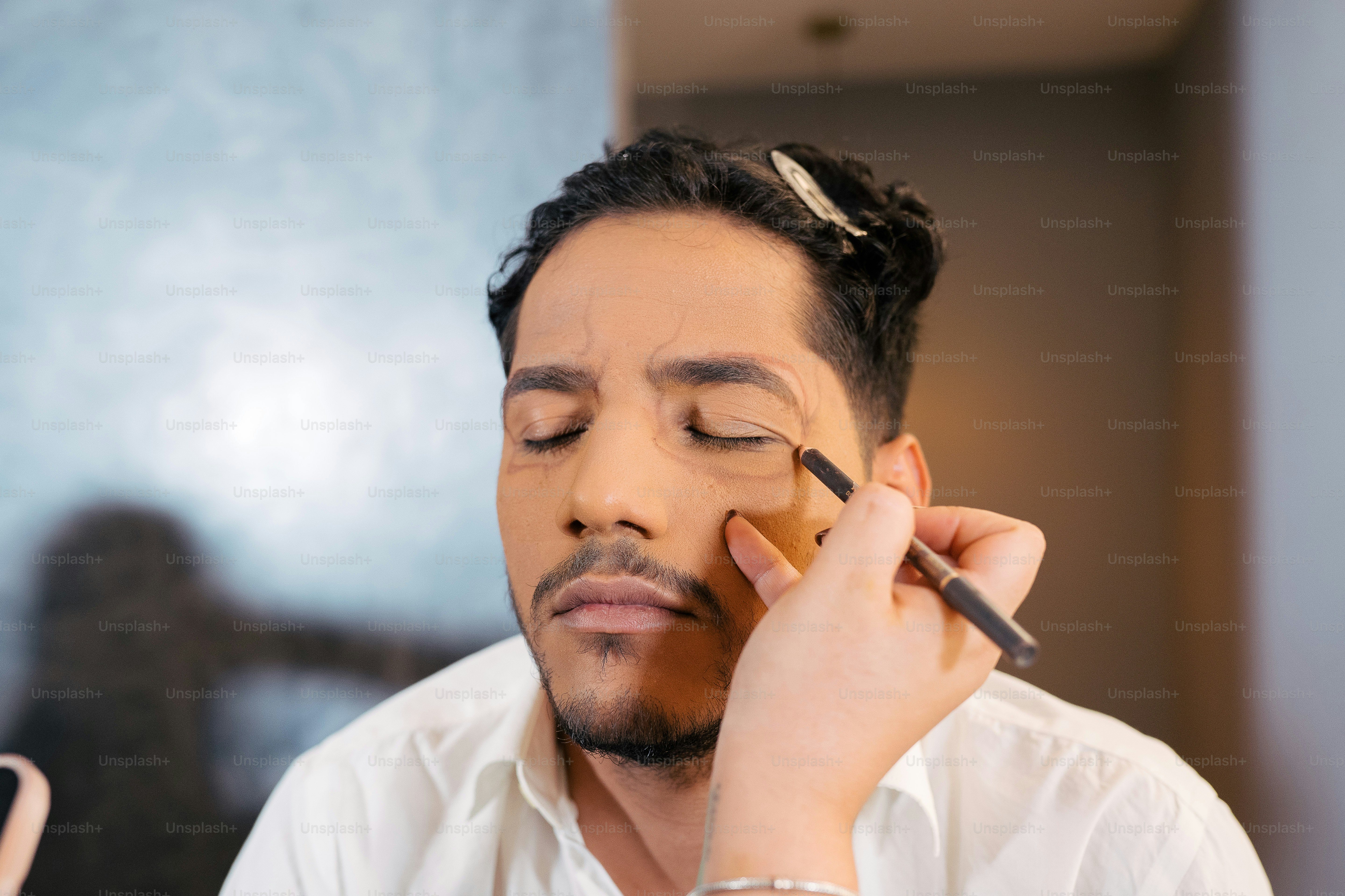 A man getting his make up done with a brush photo – Halloween Image on ...