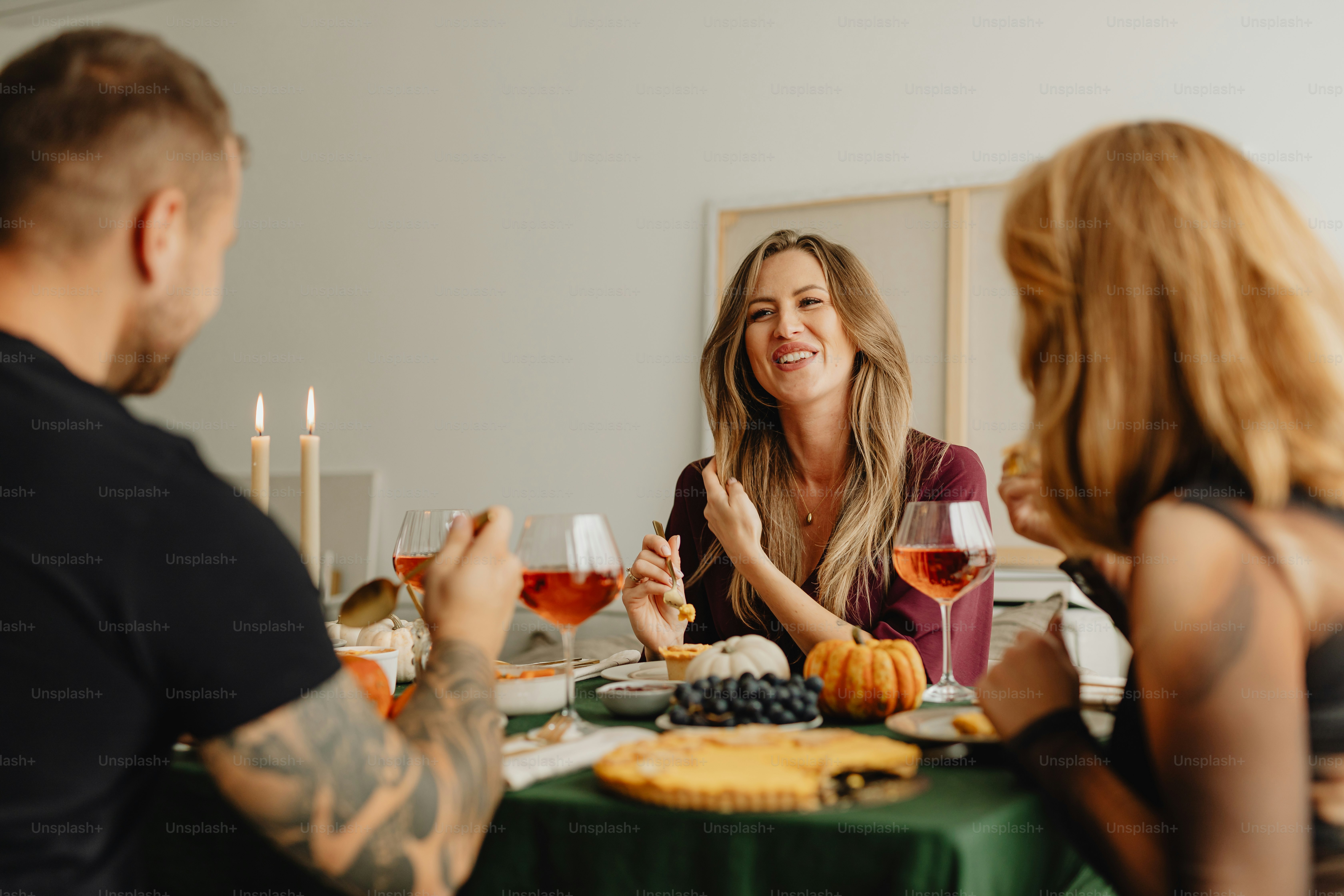 A group of people sitting around a table with food photo – Thanksgiving ...