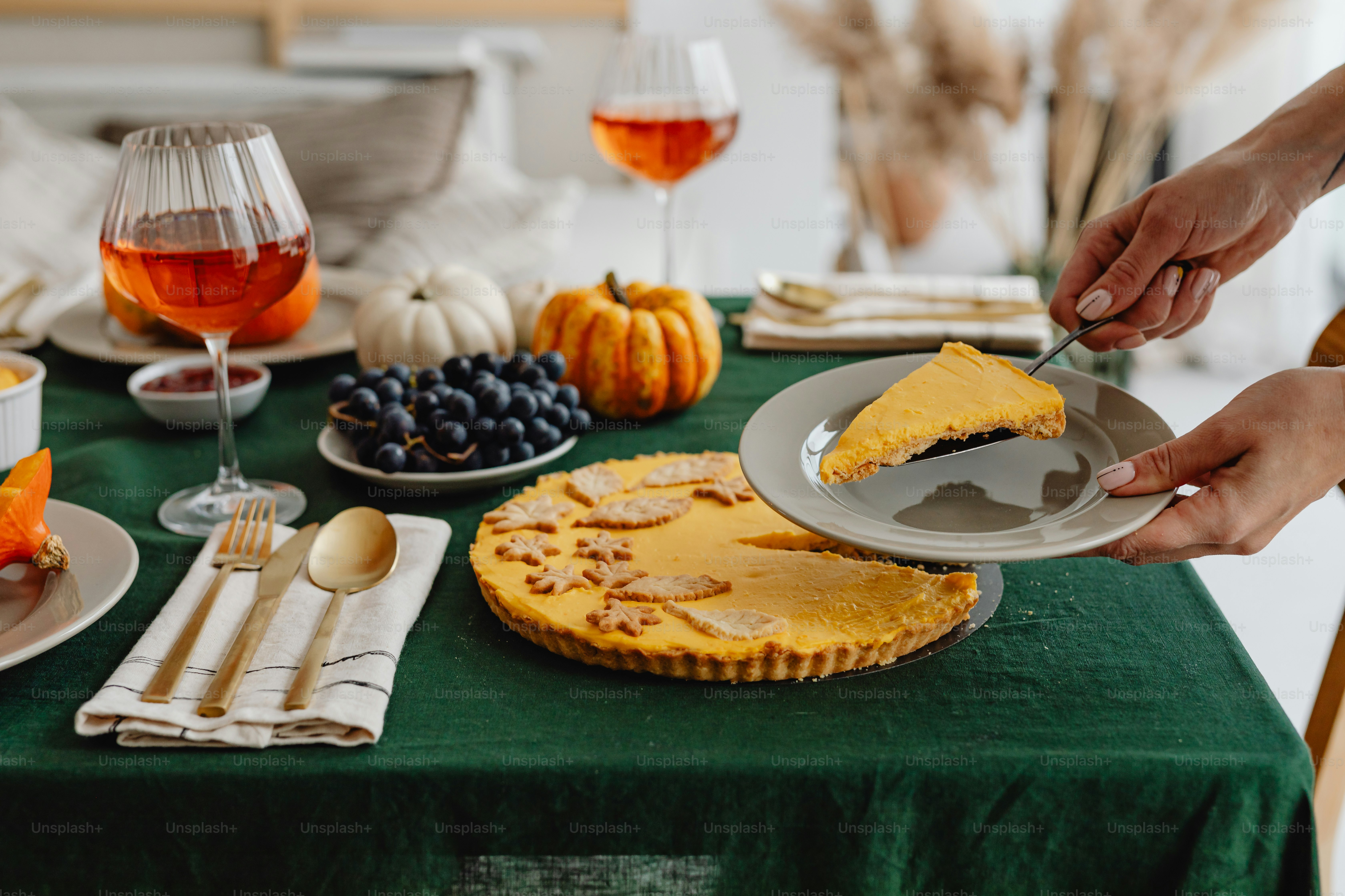 A person cutting a slice of pie on a plate photo – Thanksgiving table ...