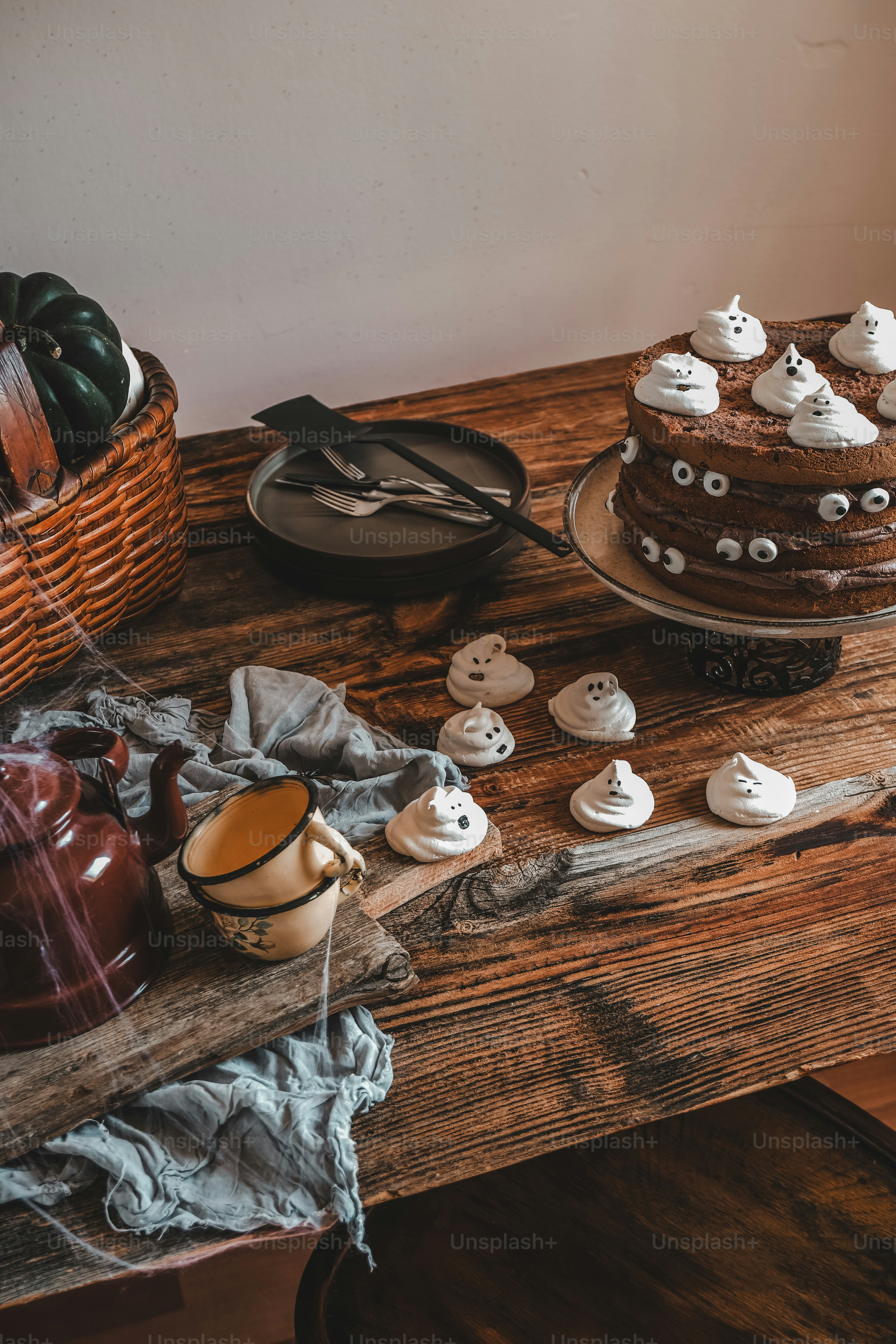 A wooden table topped with lots of cakes photo – Meringue ghosts Image ...