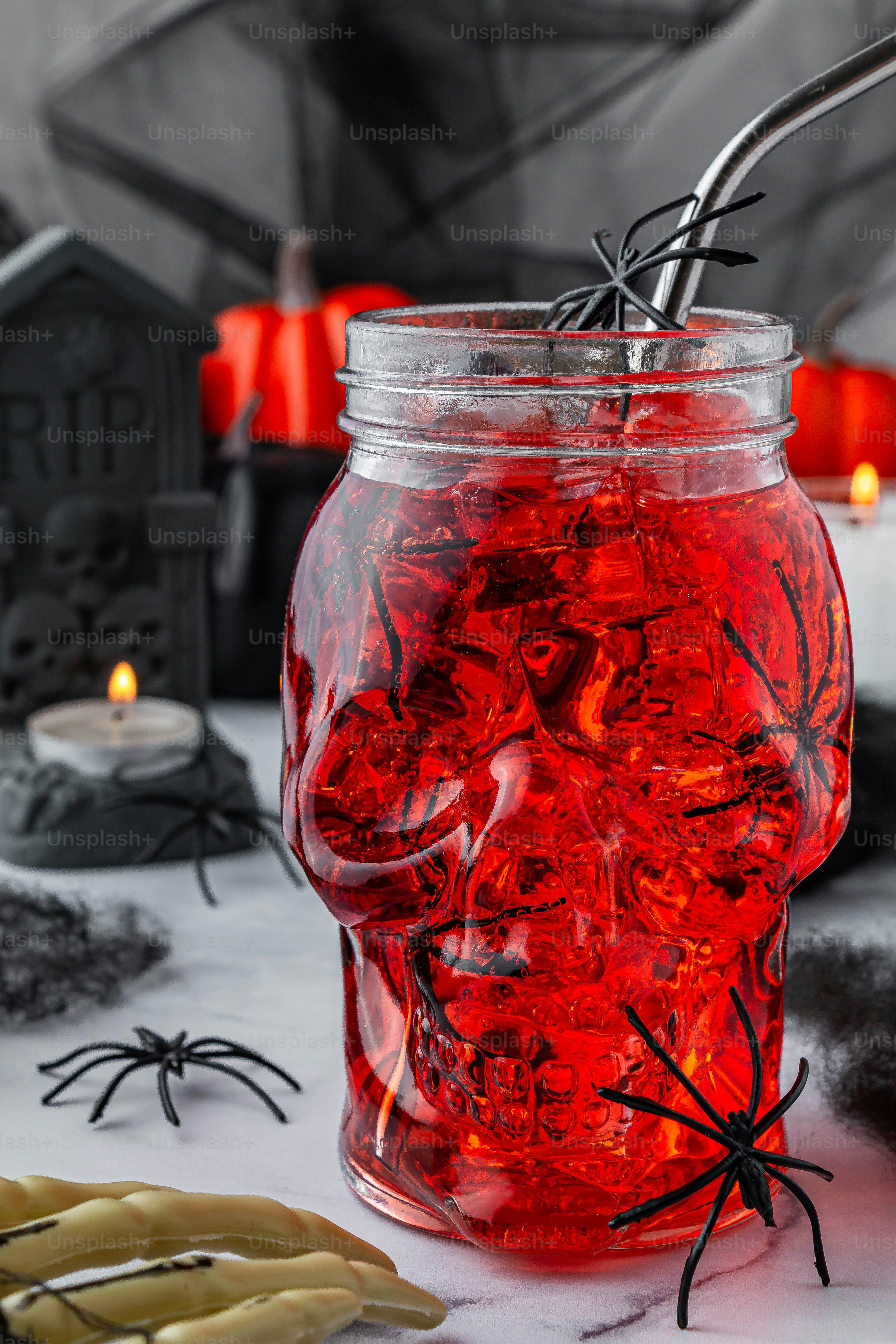 A jar filled with red liquid next to halloween decorations photo ...
