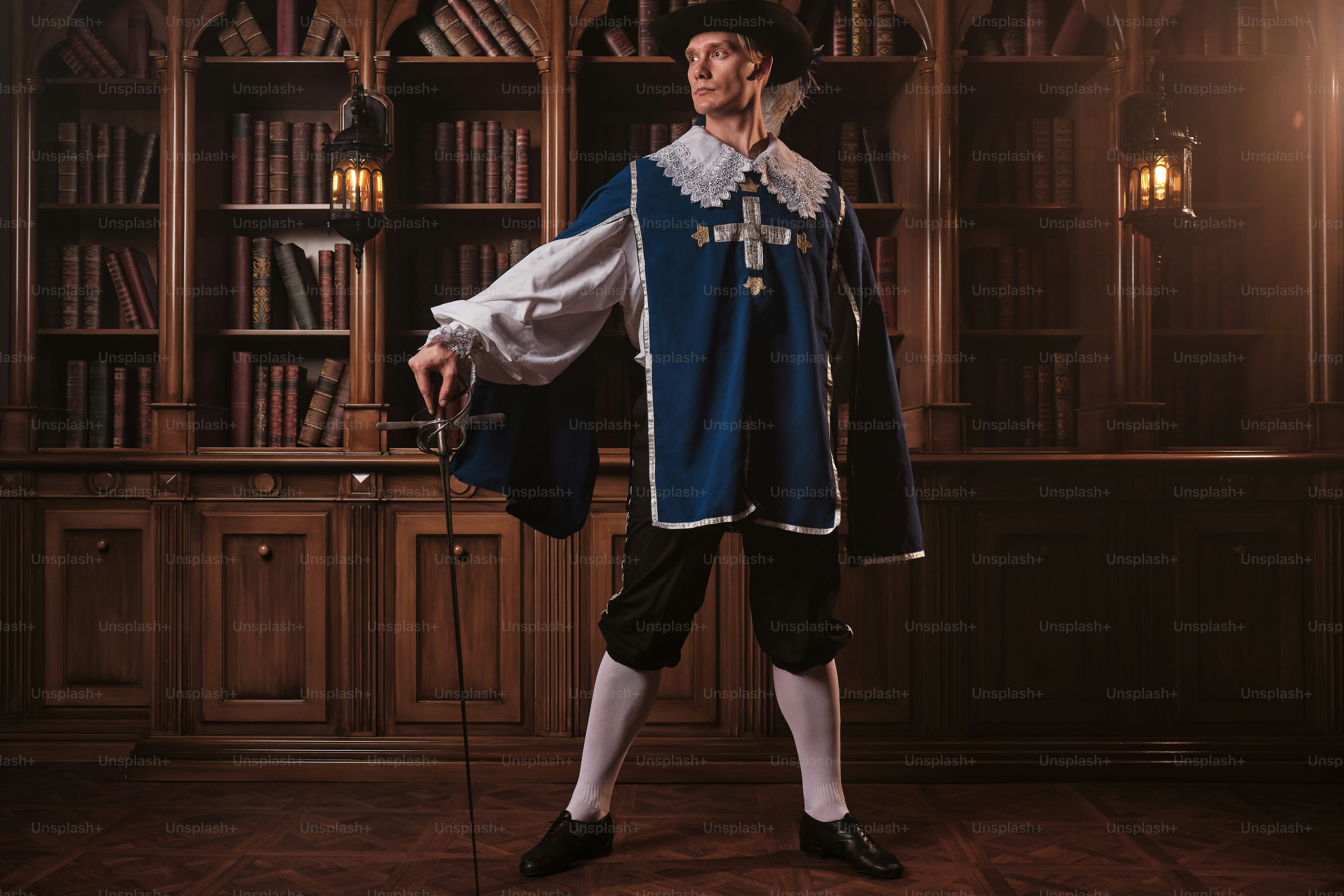 A man dressed in a renaissance costume standing in front of a bookshelf ...