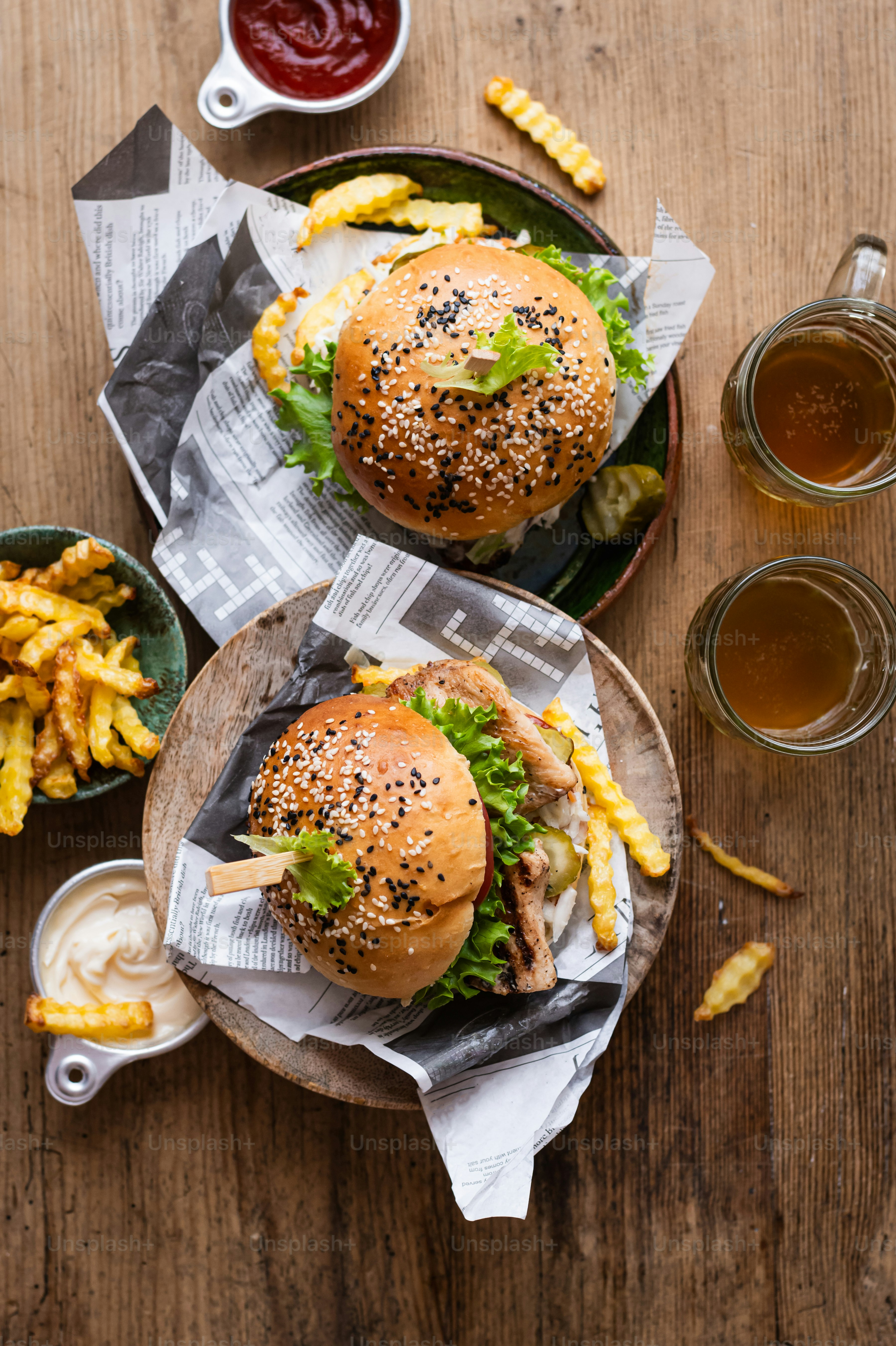 A wooden table topped with two burgers and fries photo – Pub food Image ...