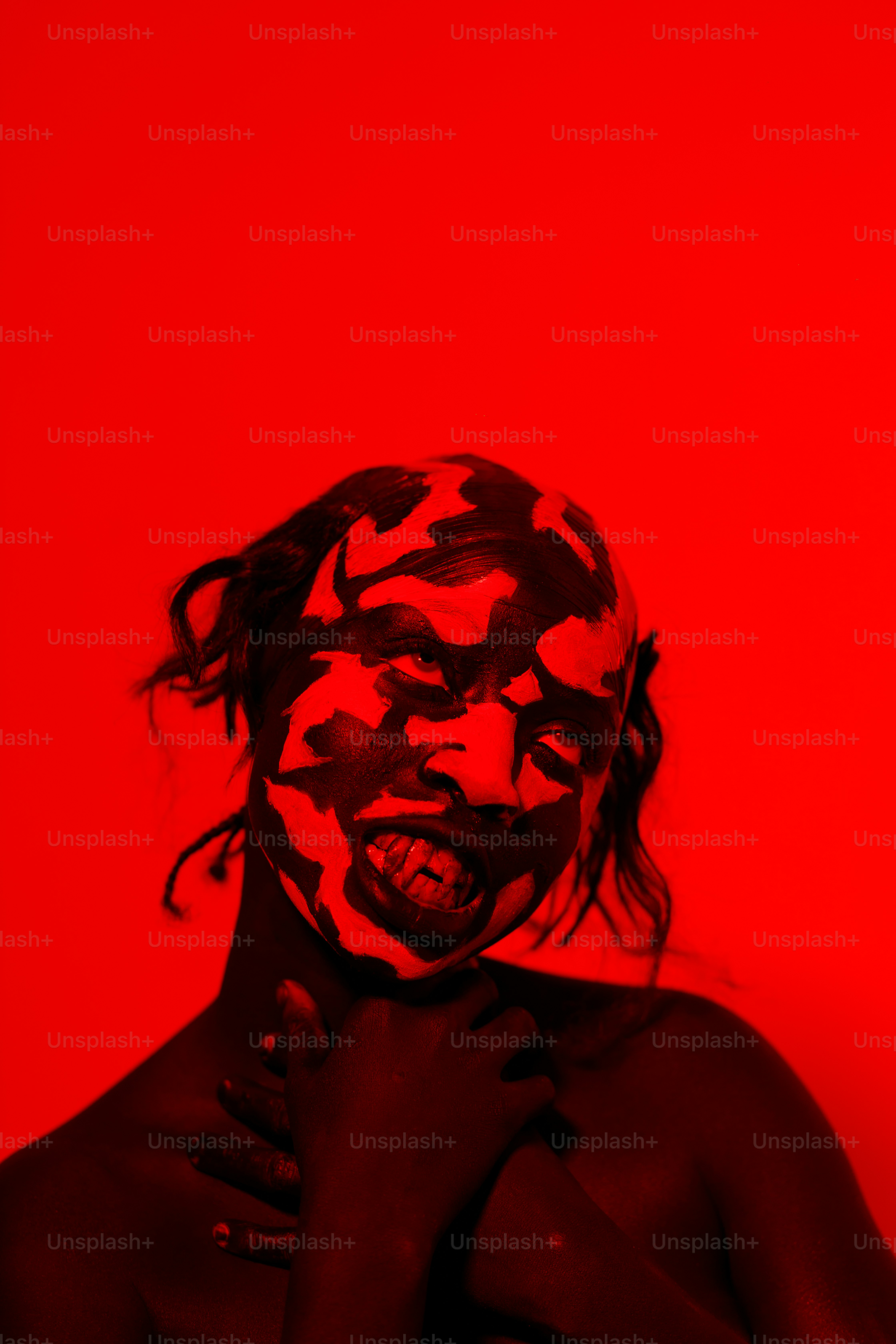 A person with a red and black face painted photo – Halloween makeup ...