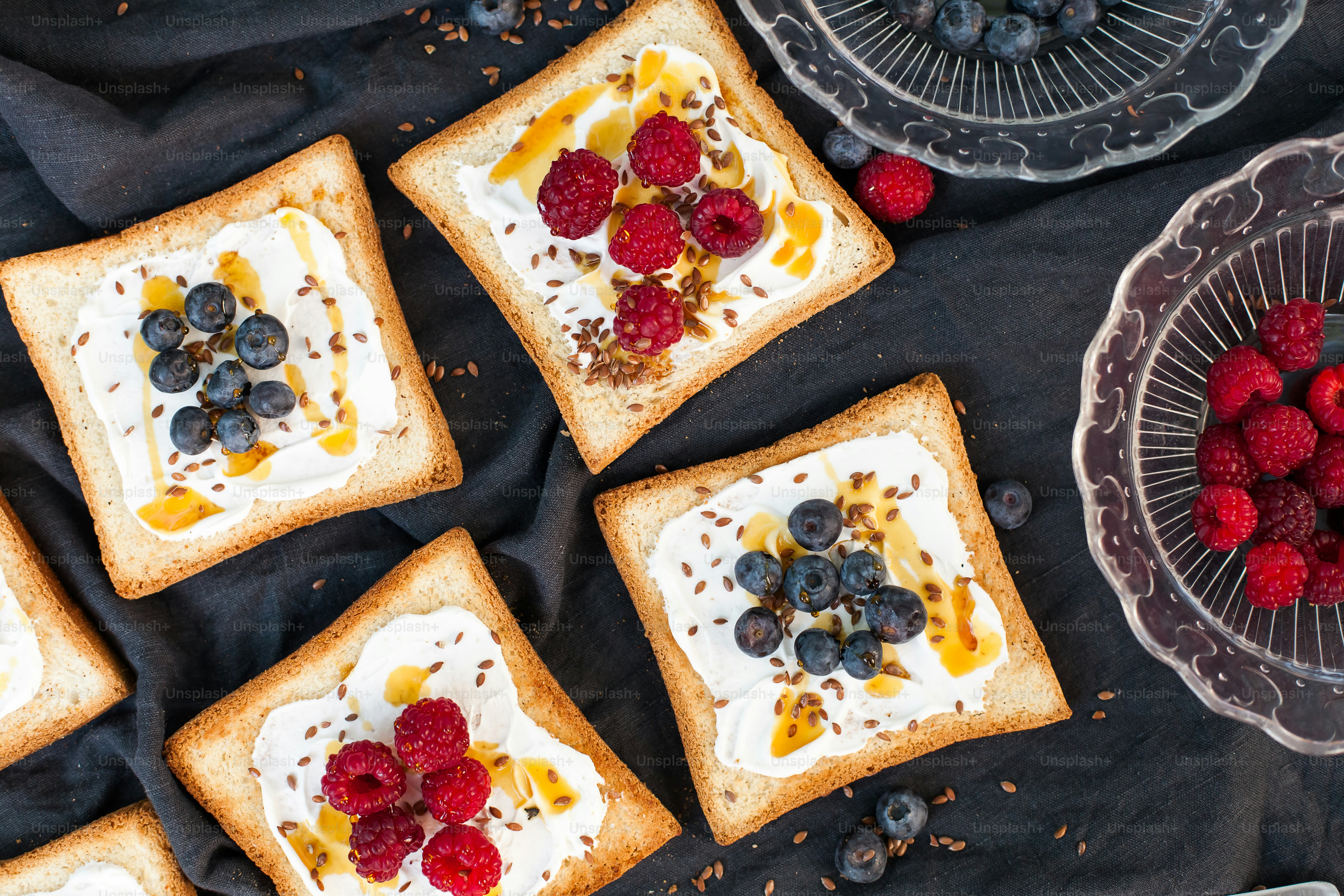 A table topped with four pieces of toast covered in fruit photo – Toast ...