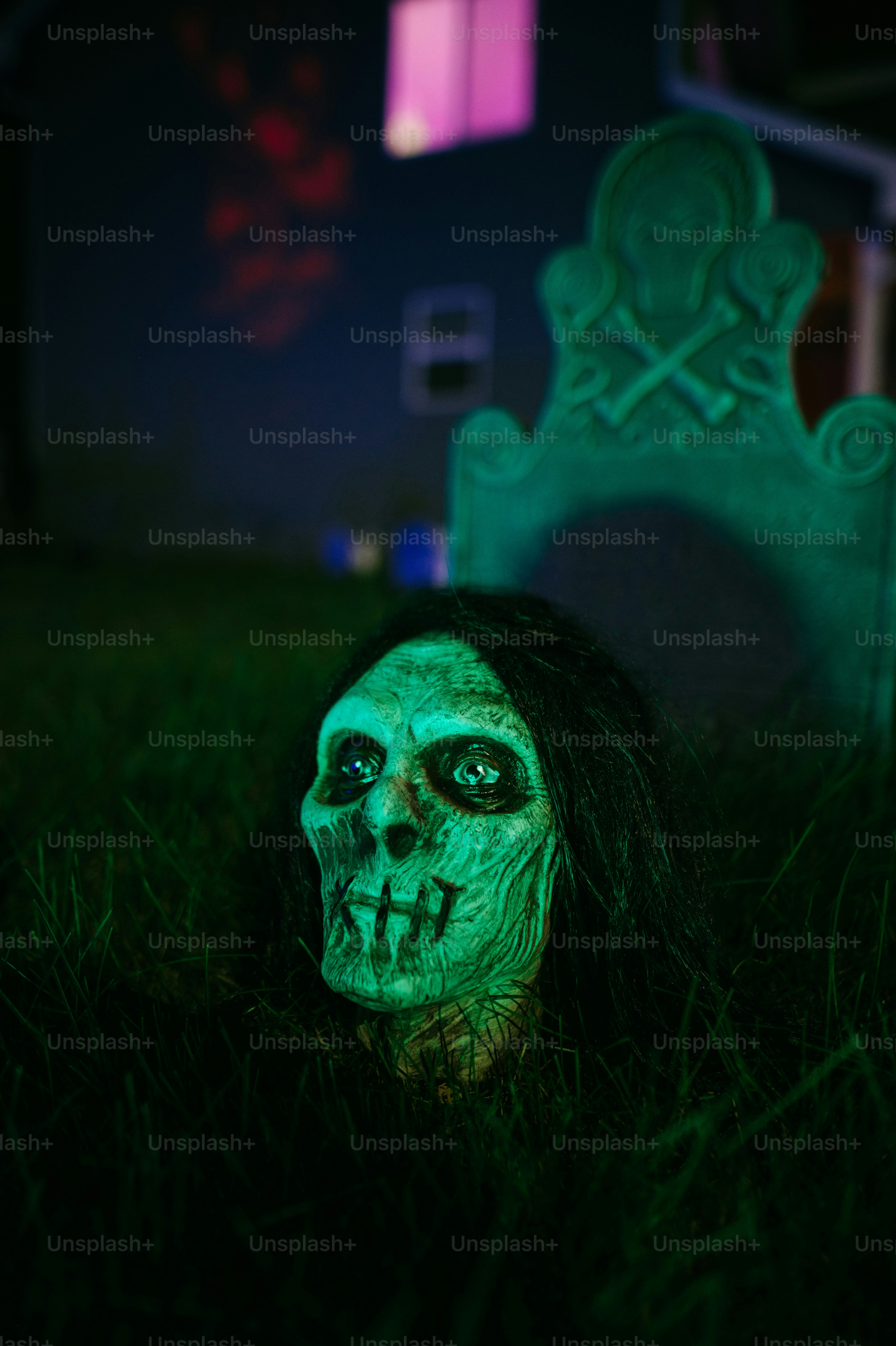 A creepy doll is laying in the grass photo – Gravestone Image on Unsplash