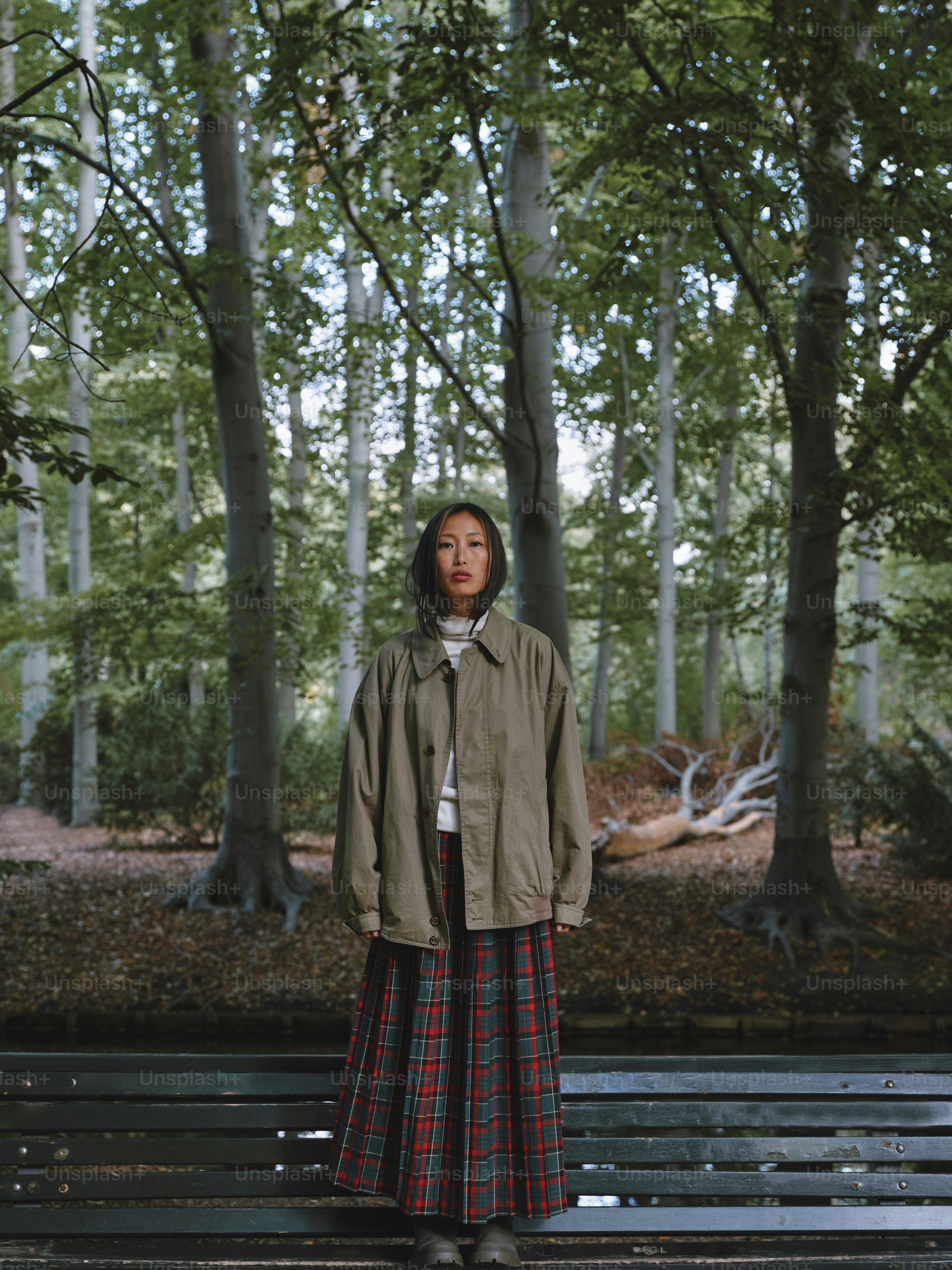 A woman standing on a bench in a forest photo – Autumn Image on Unsplash