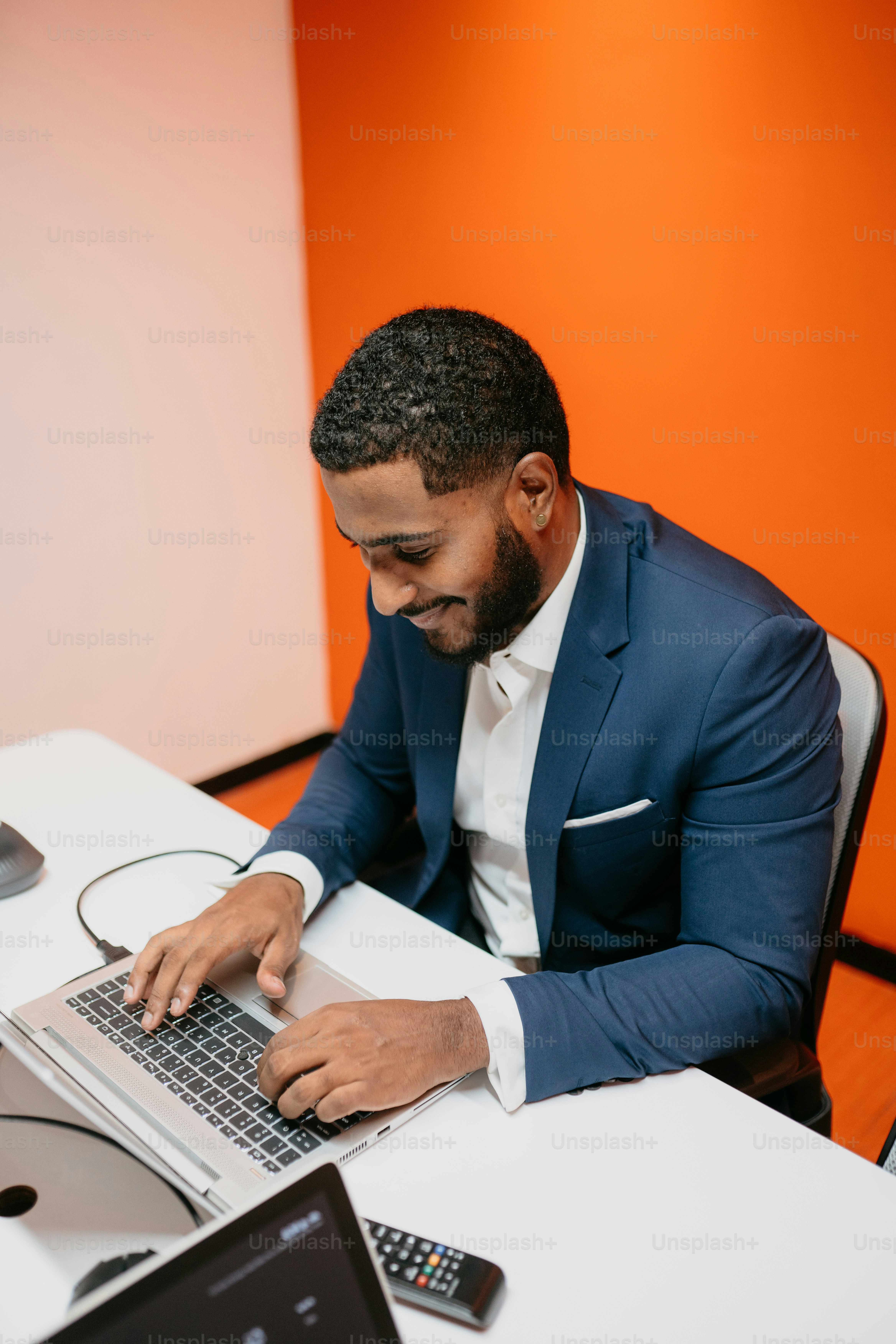 A man sitting at a desk using a laptop computer photo – Office Image on ...