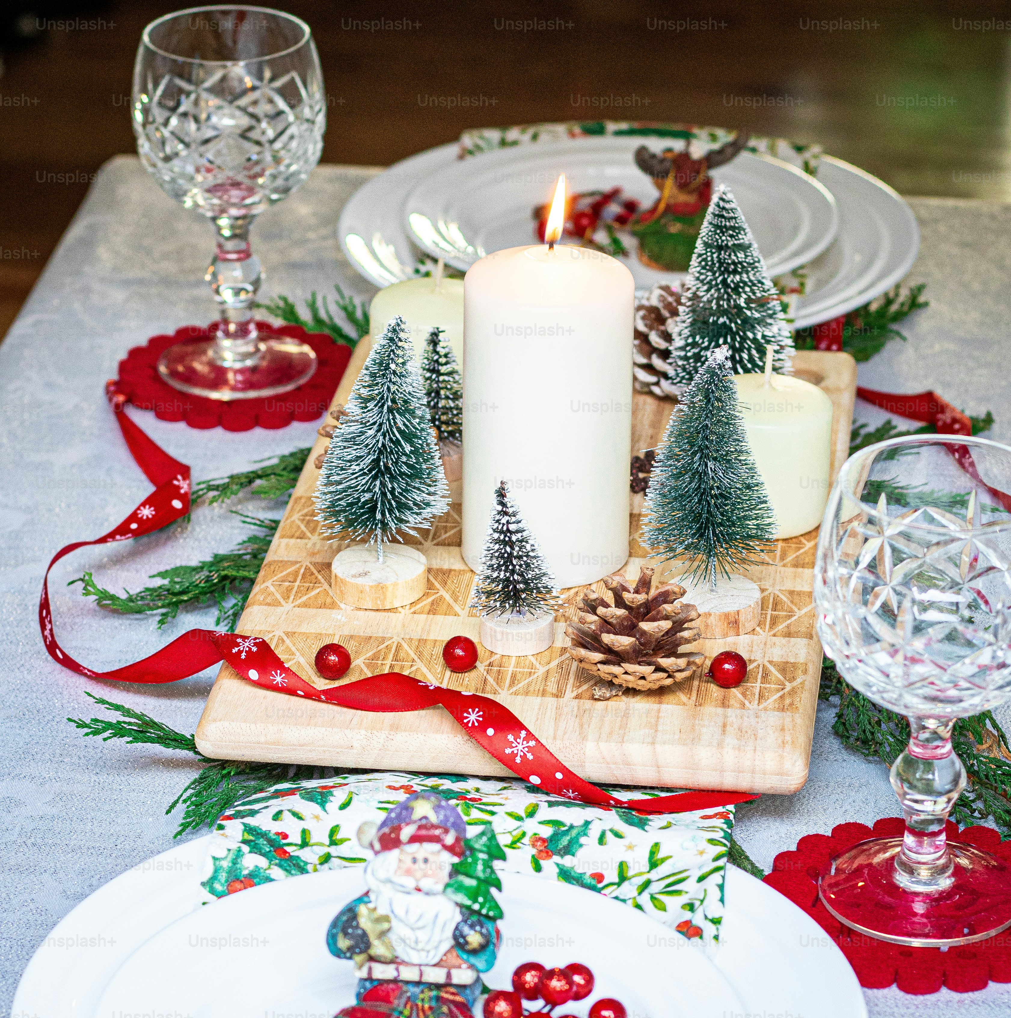 A christmas table setting with a candle and plates photo – Christmas ...