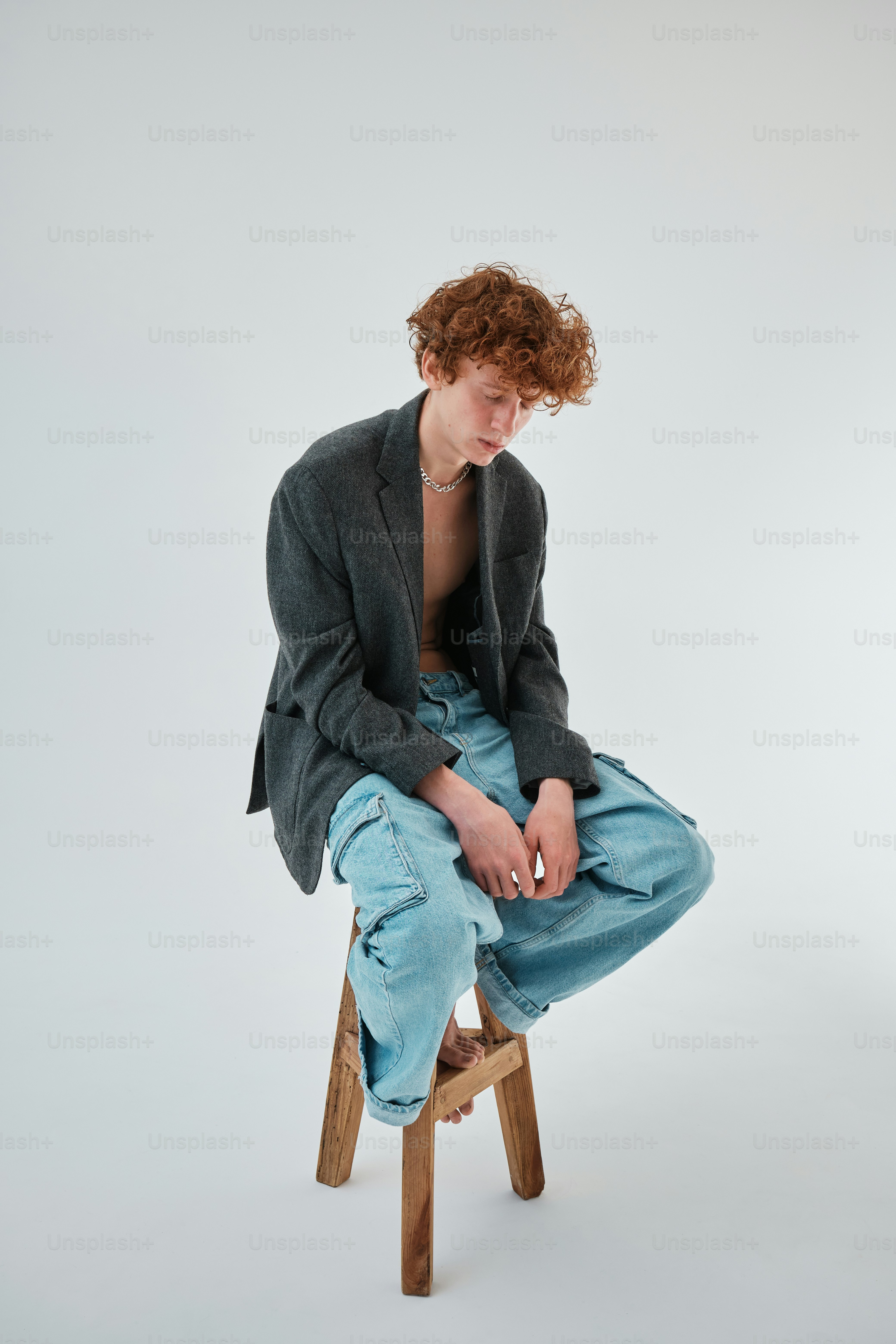 A man sitting on top of a wooden stool photo – Portrait Image on Unsplash