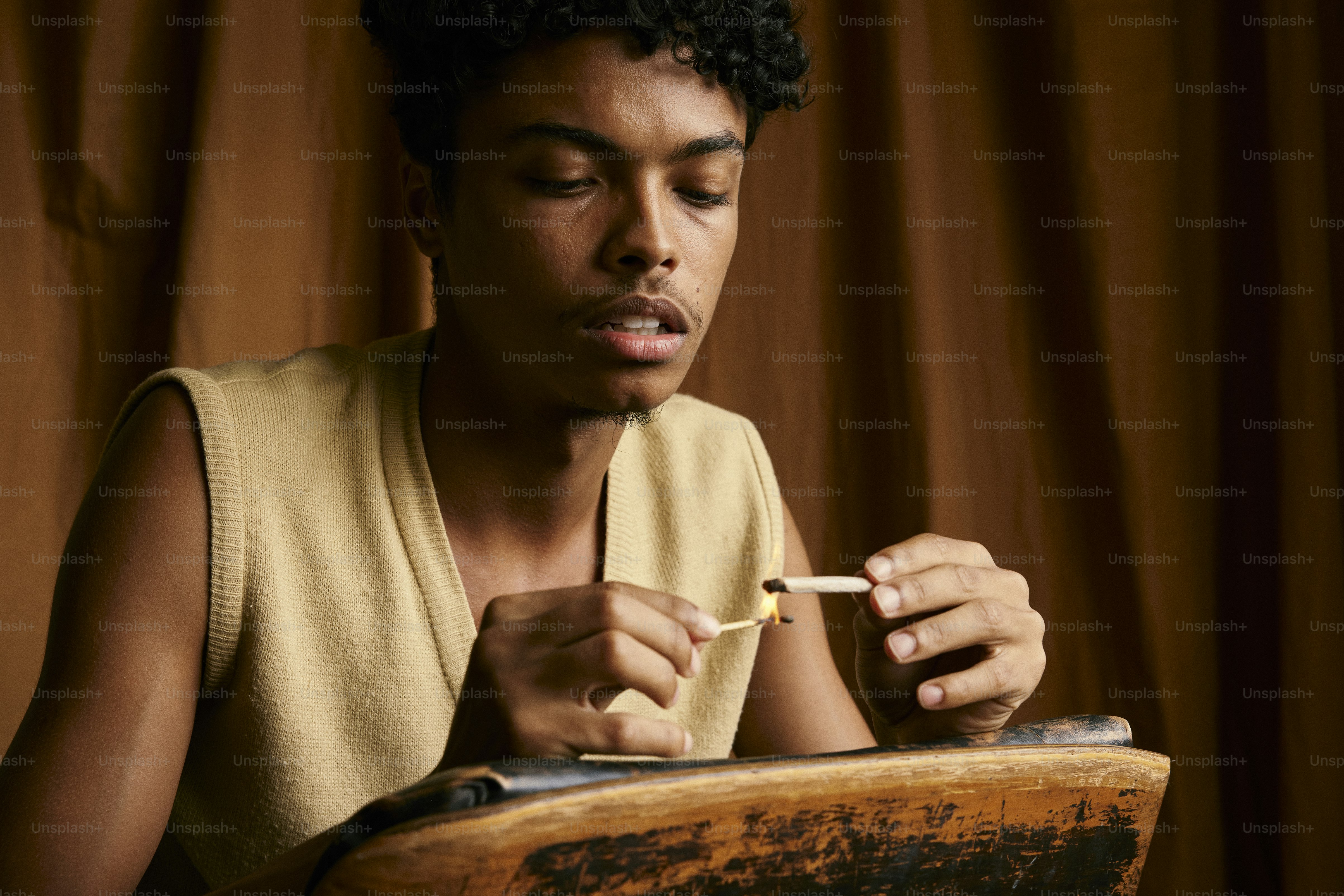 A woman smoking a cigarette in front of a wooden table photo – Tank top ...