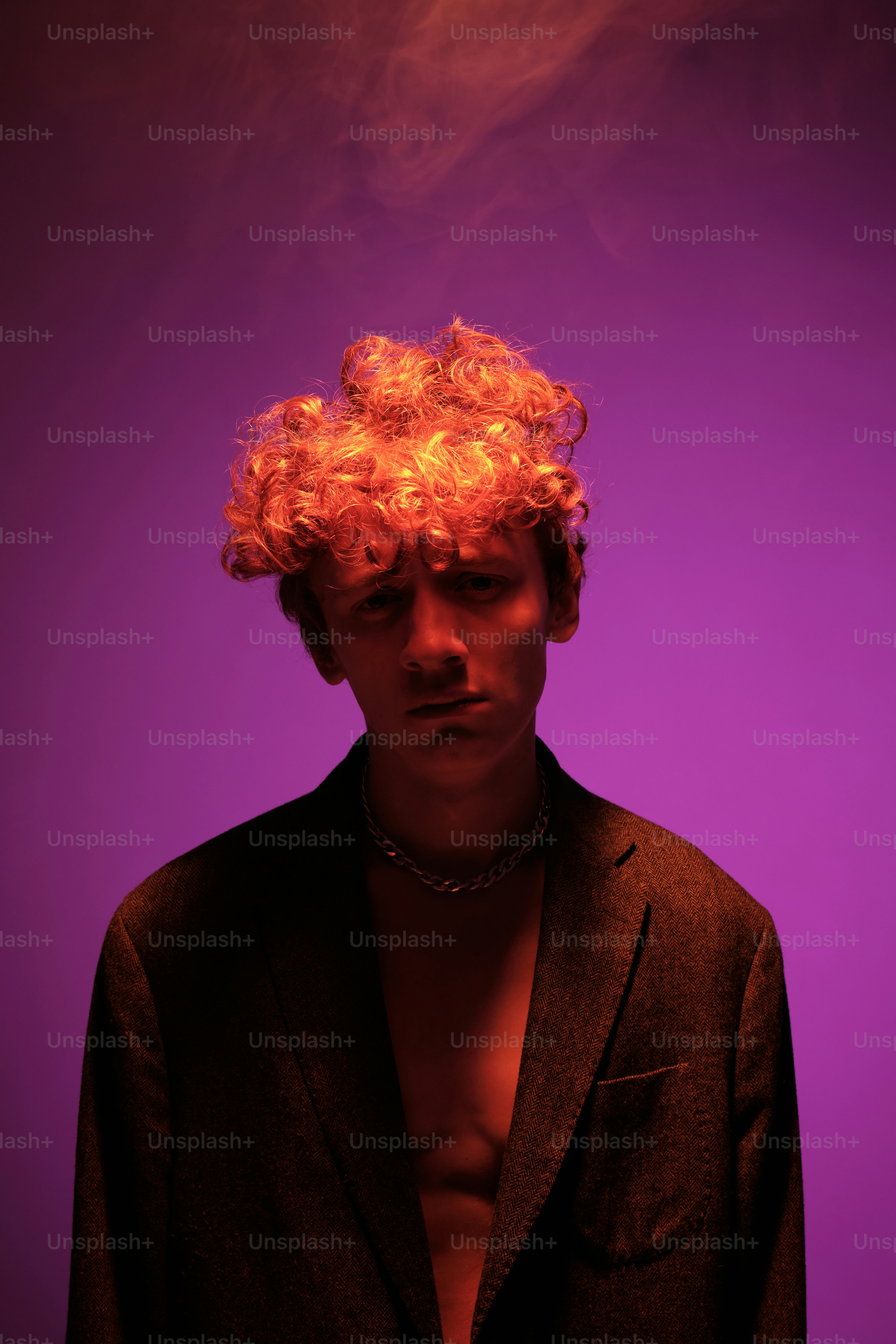 Un hombre con cabello rojo rizado parado frente a un fondo púrpura foto ...
