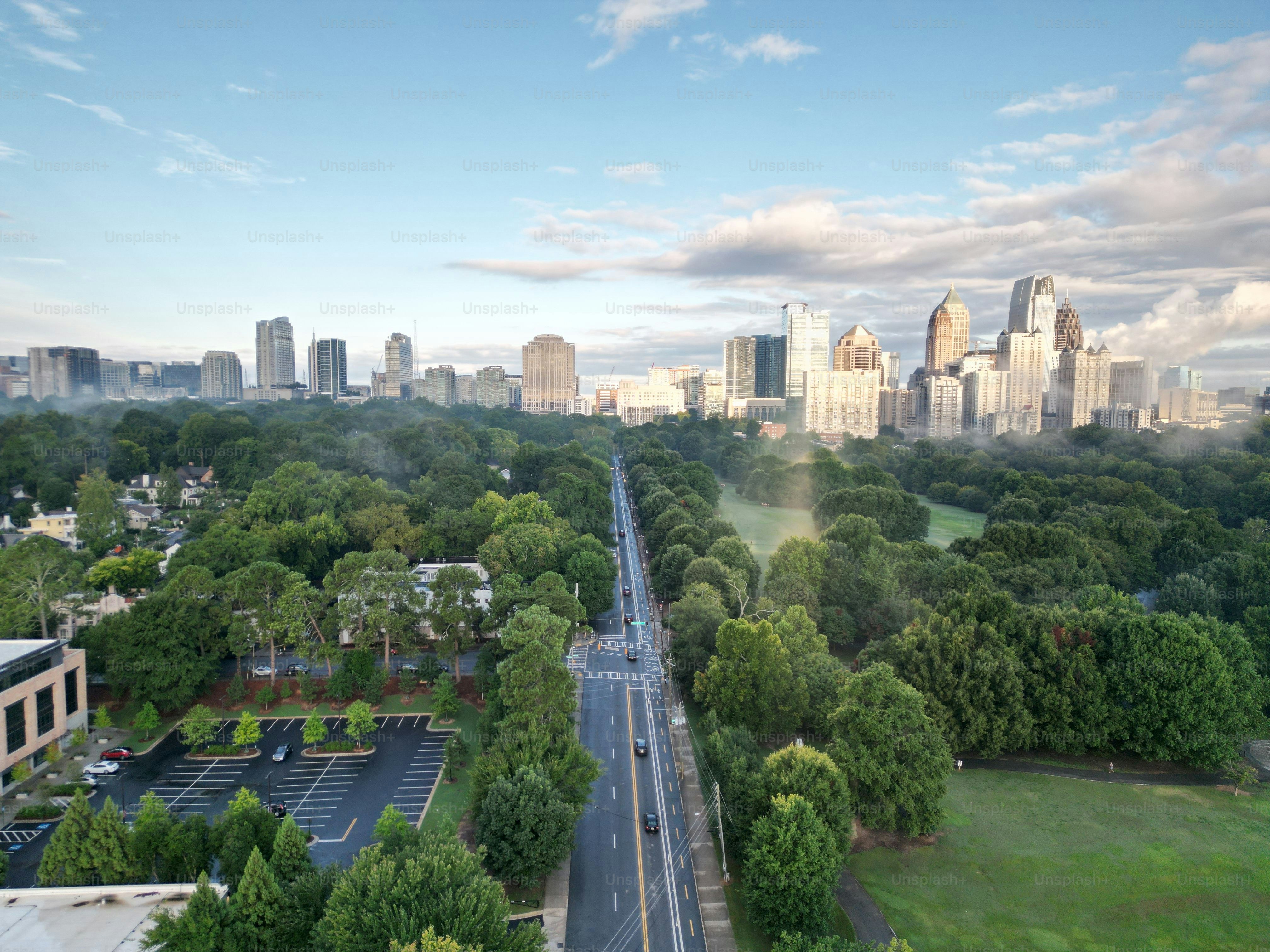 An Aerial view of green park with Atlanta skyline in the distance under ...