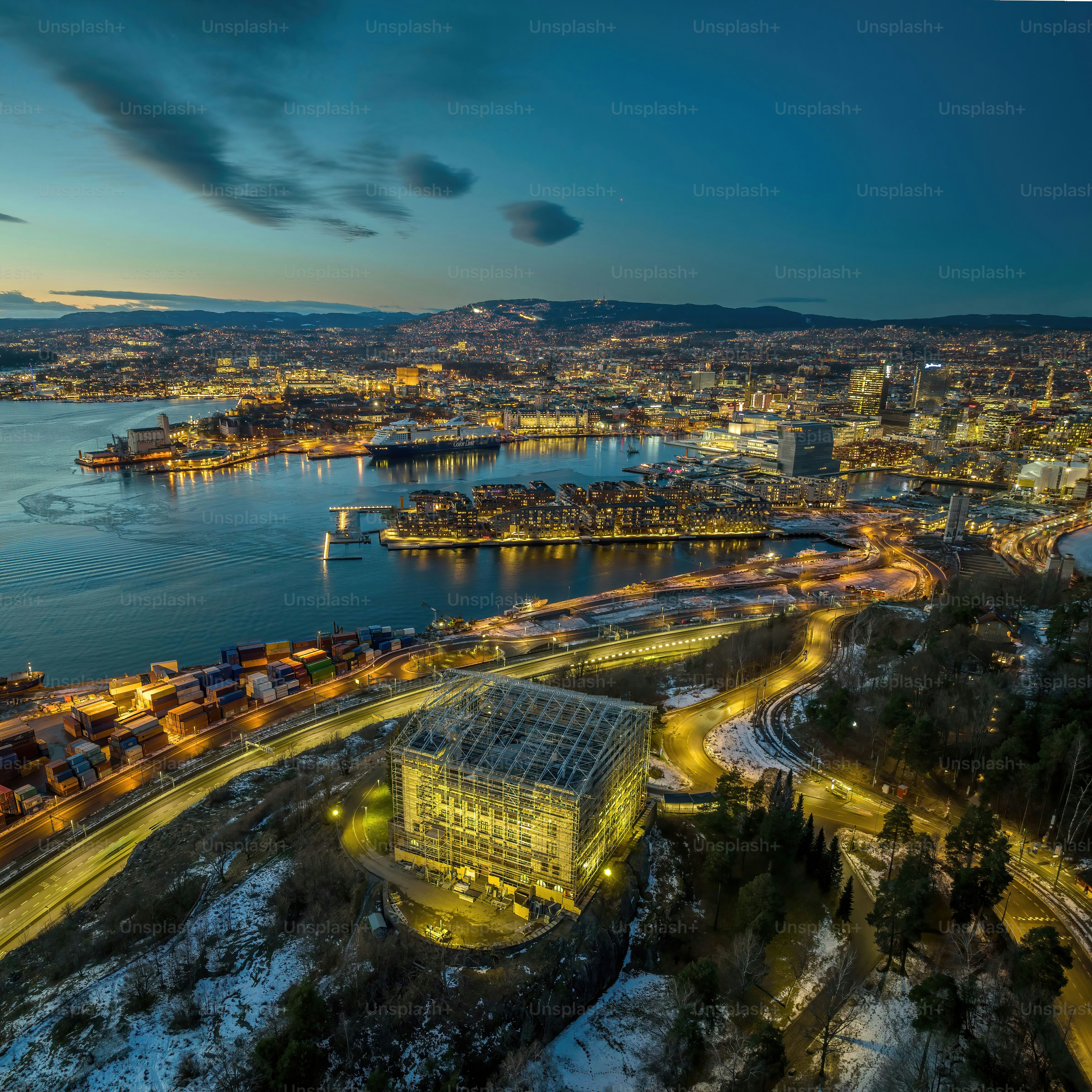 An aerial shot of Oslo at sunset, with lots of buildings and lights ...