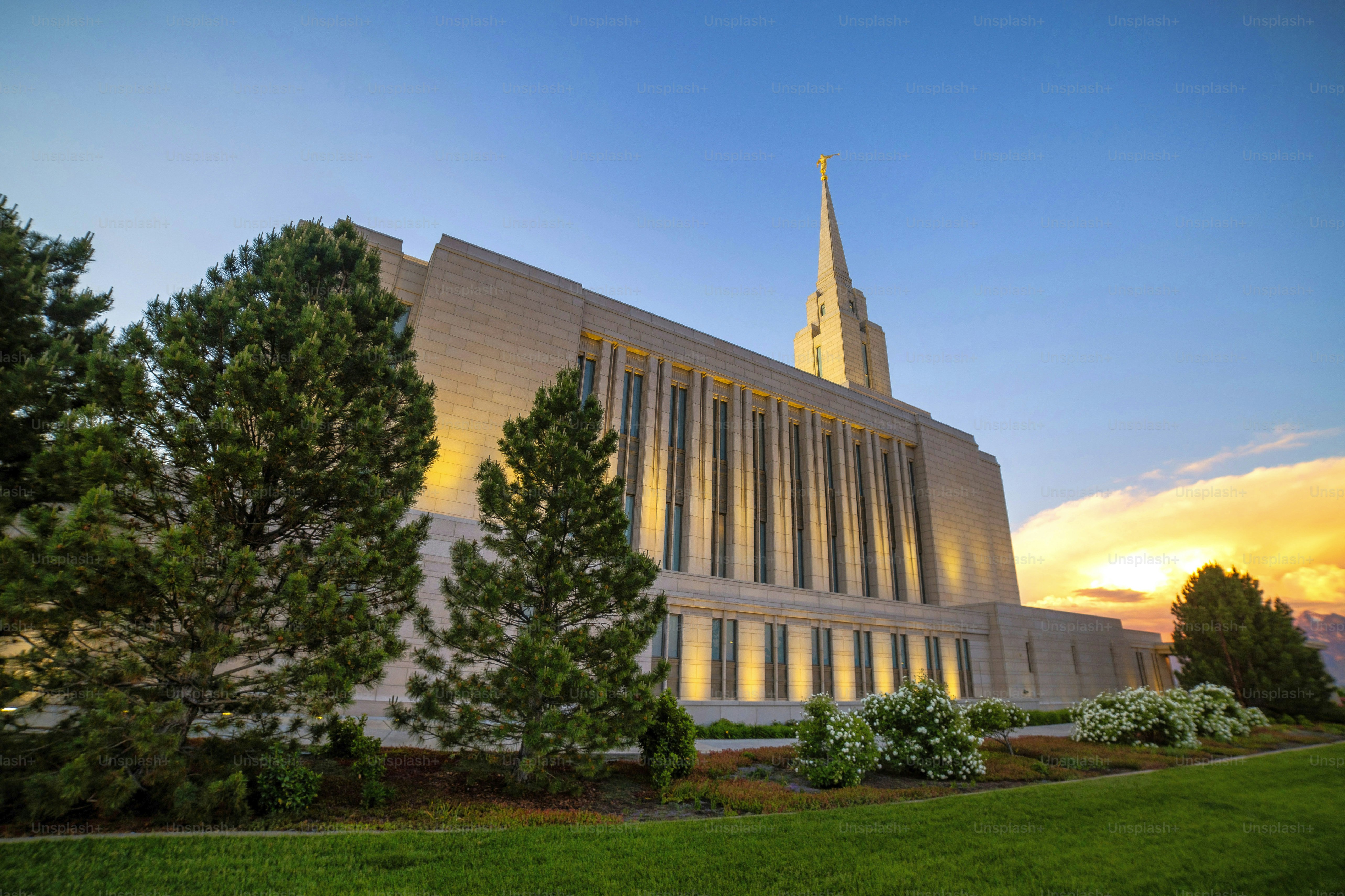 A mormon church in Utah at the sunset in a beautiful park with green ...