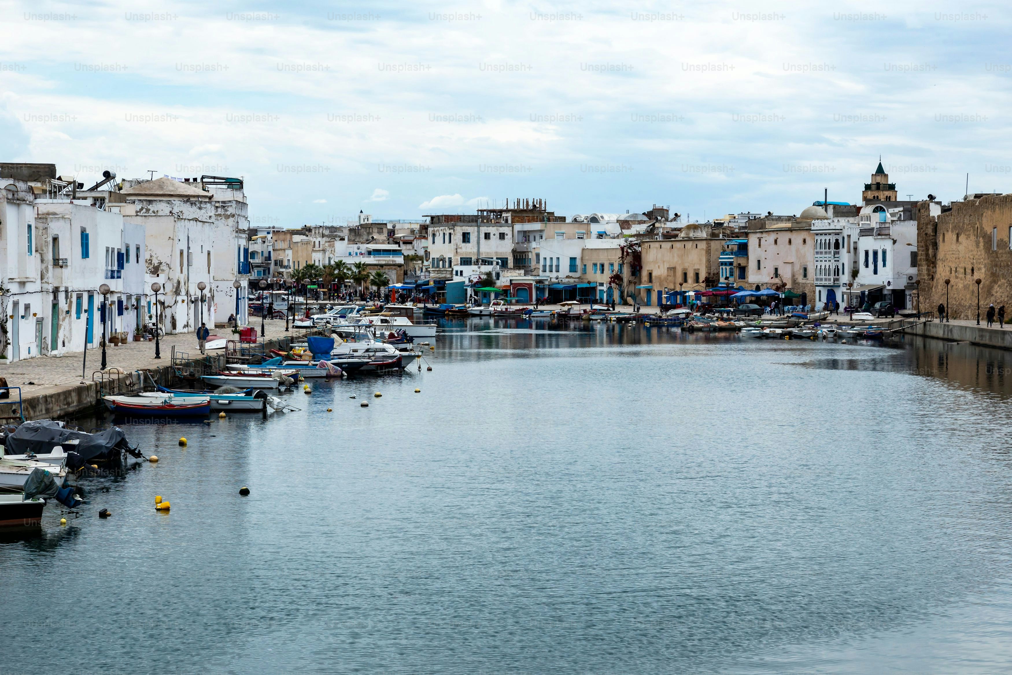 This stock photo shows a tranquil port in Bizerte, Tunisia, with a boat ...