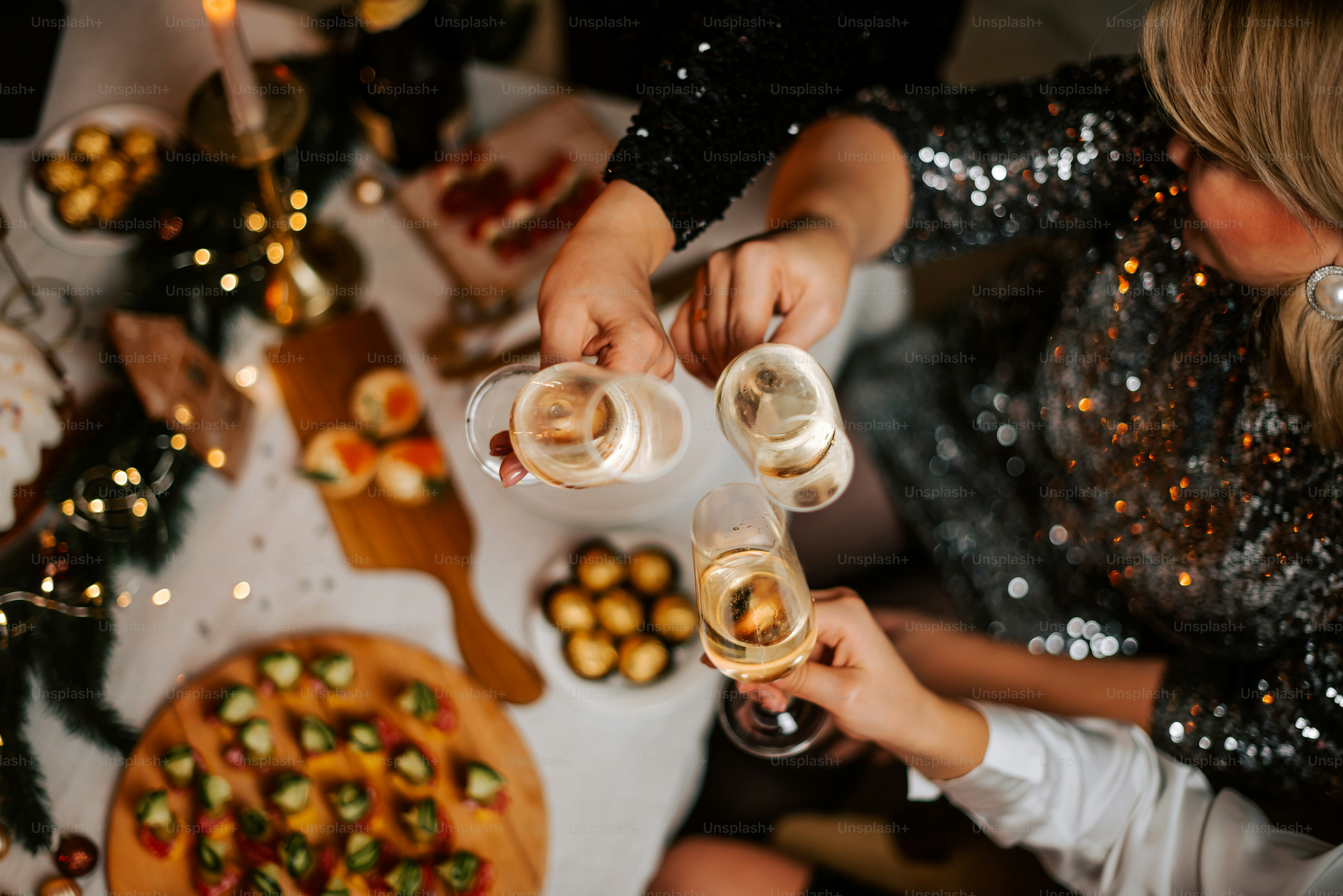 A group of people holding wine glasses and sparklers photo – New year ...