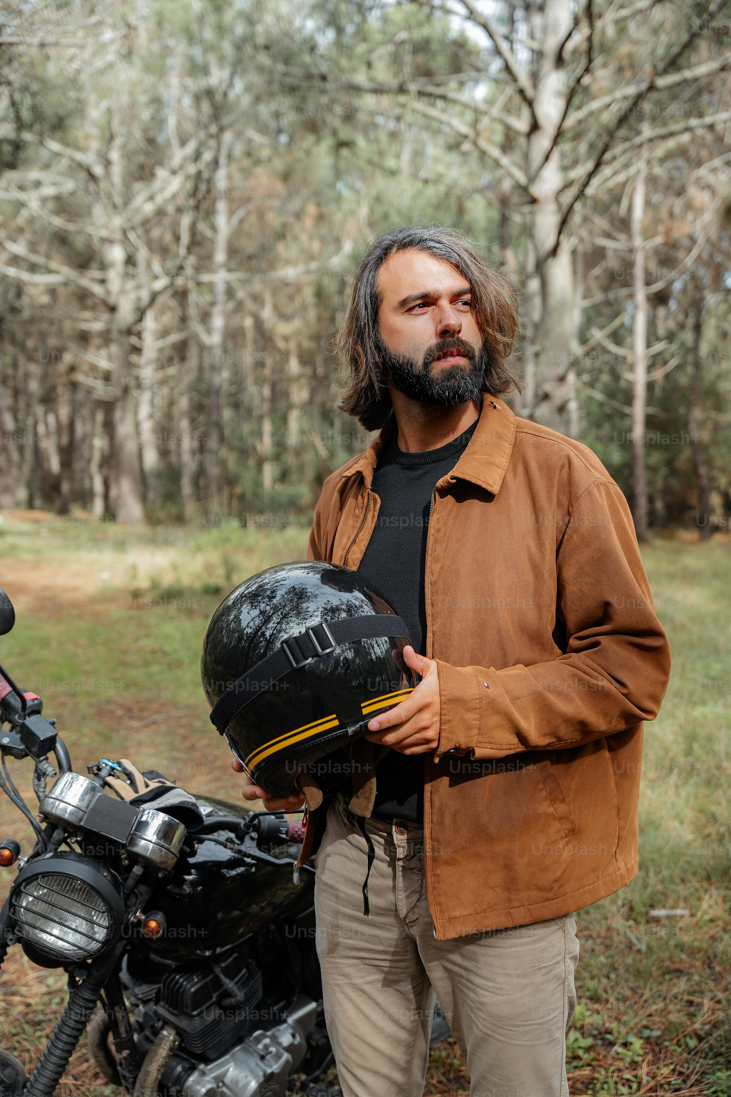 A man sitting on a motorcycle in the woods photo – Adventure Image on ...