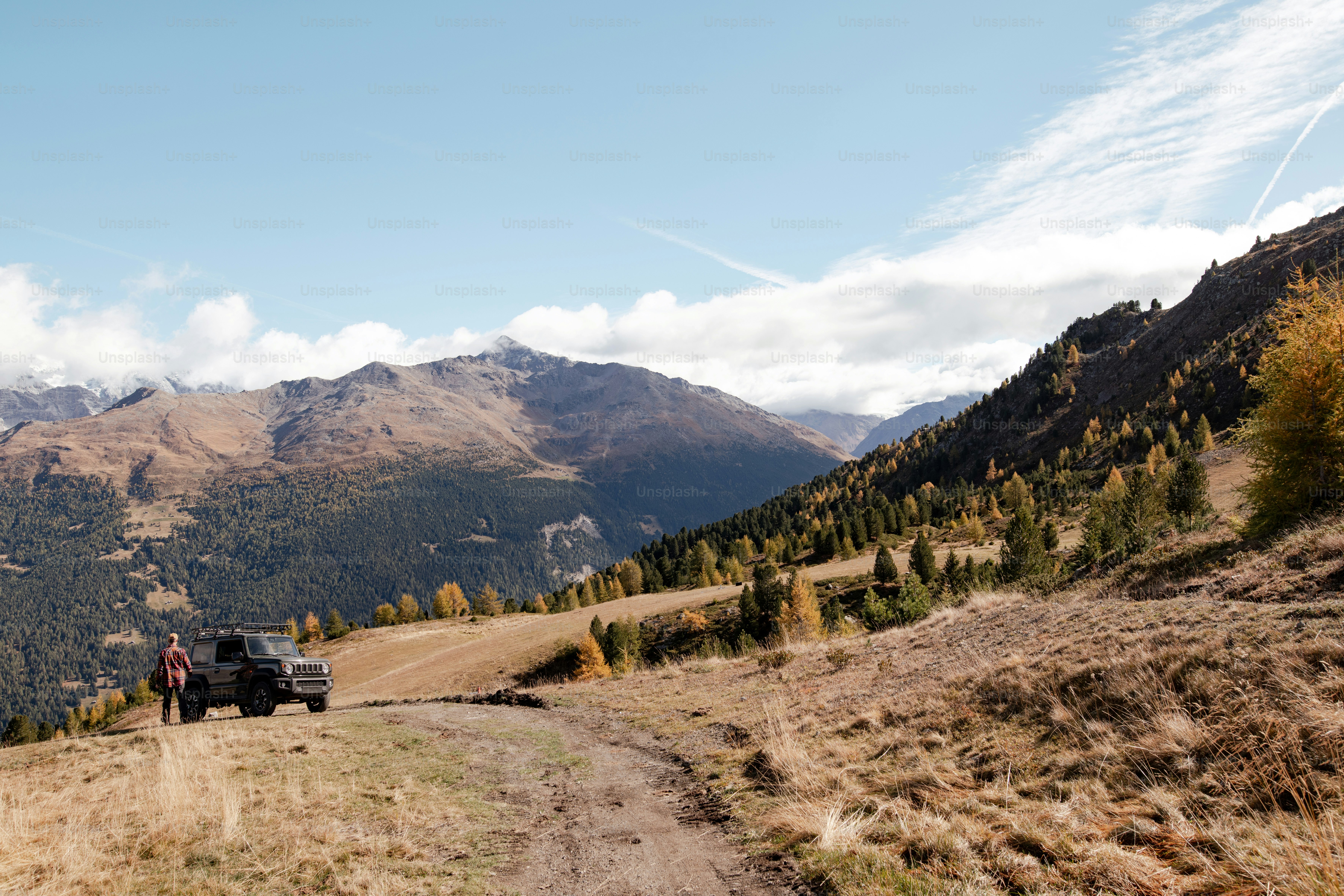 A jeep driving down a dirt road in the mountains photo – Italy Image on ...